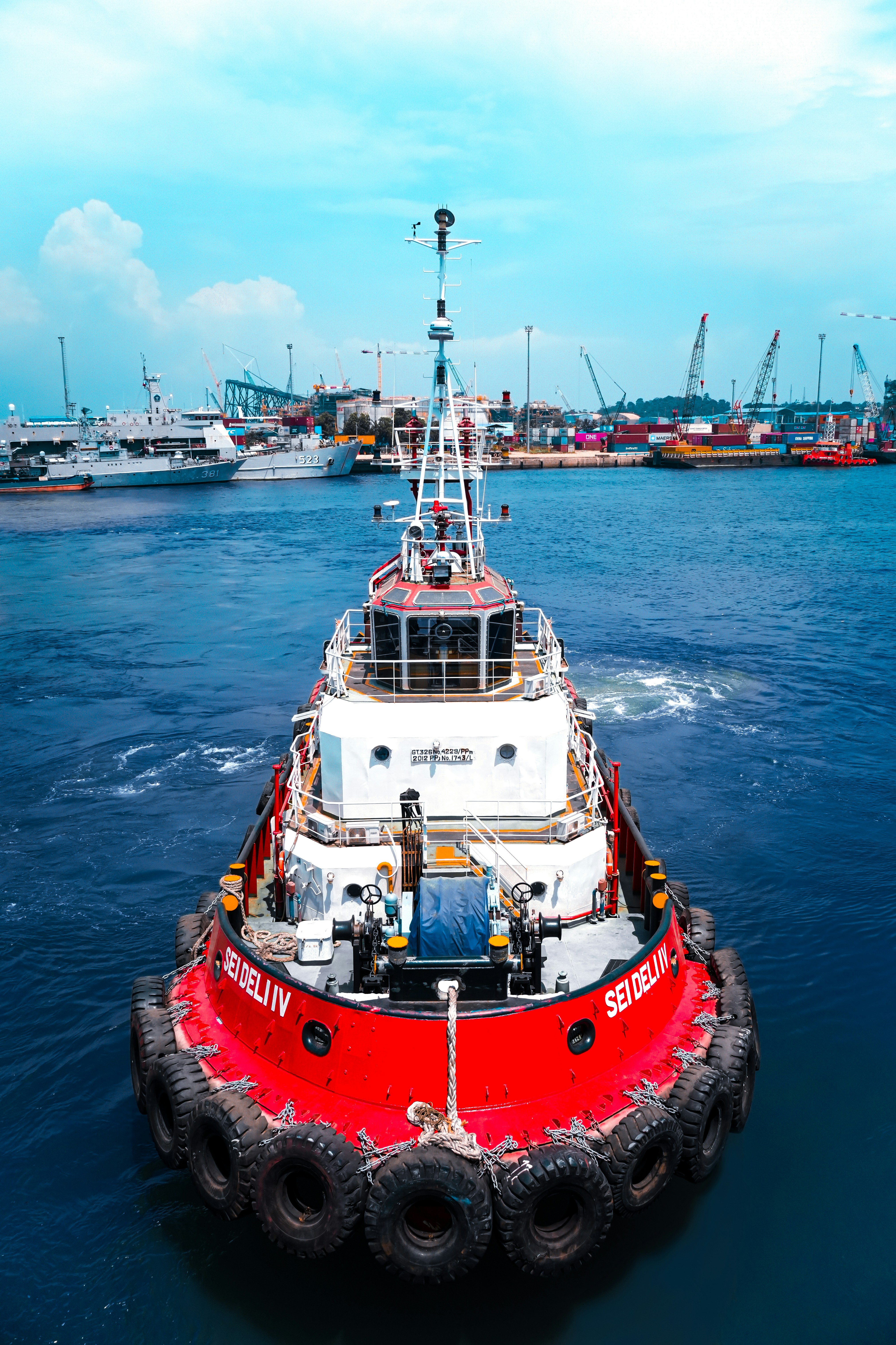 A red and white tugboat moves through blue water. photo – Free ...