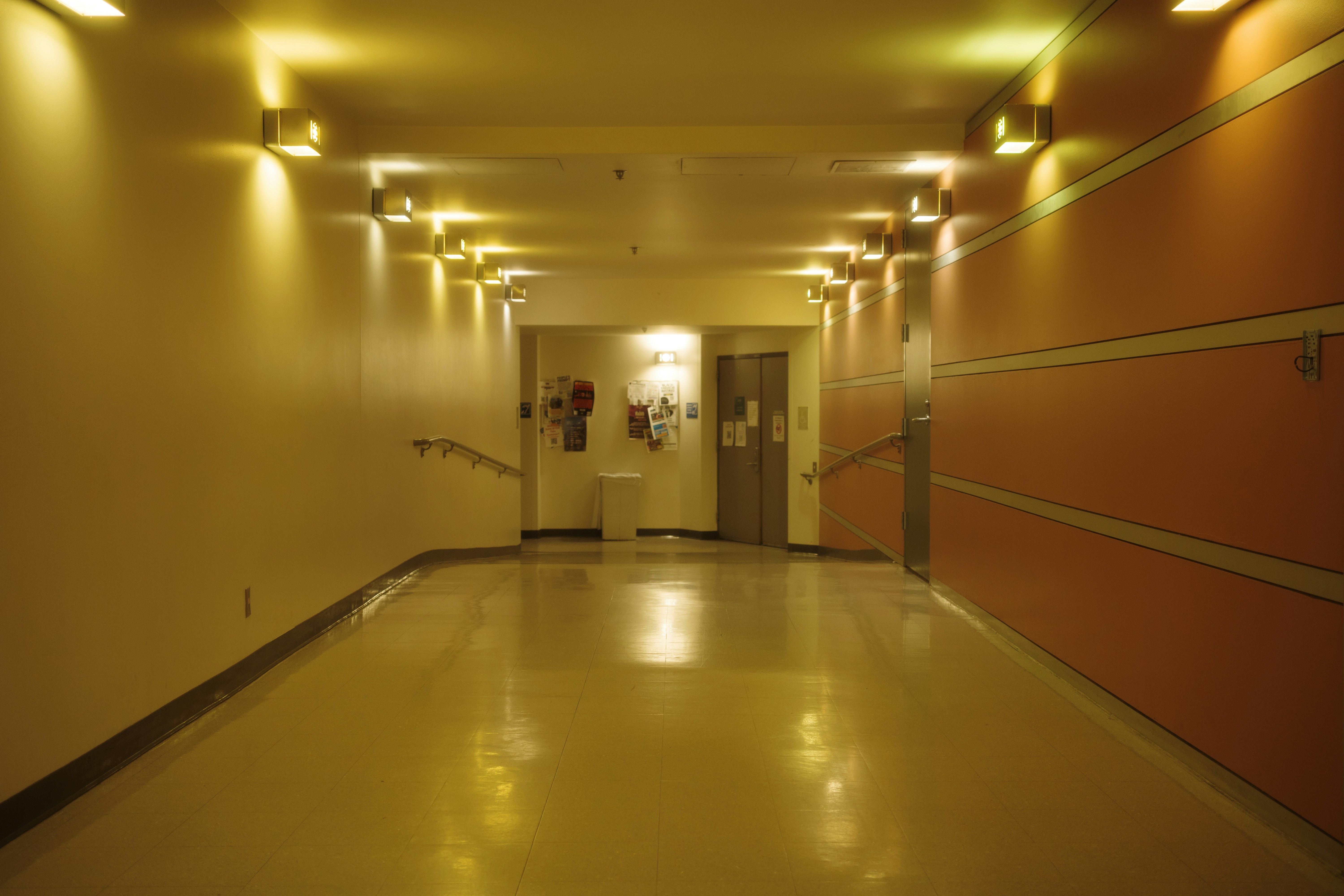 Well-lit hospital hallway with doors at the end of the corridor. photo ...