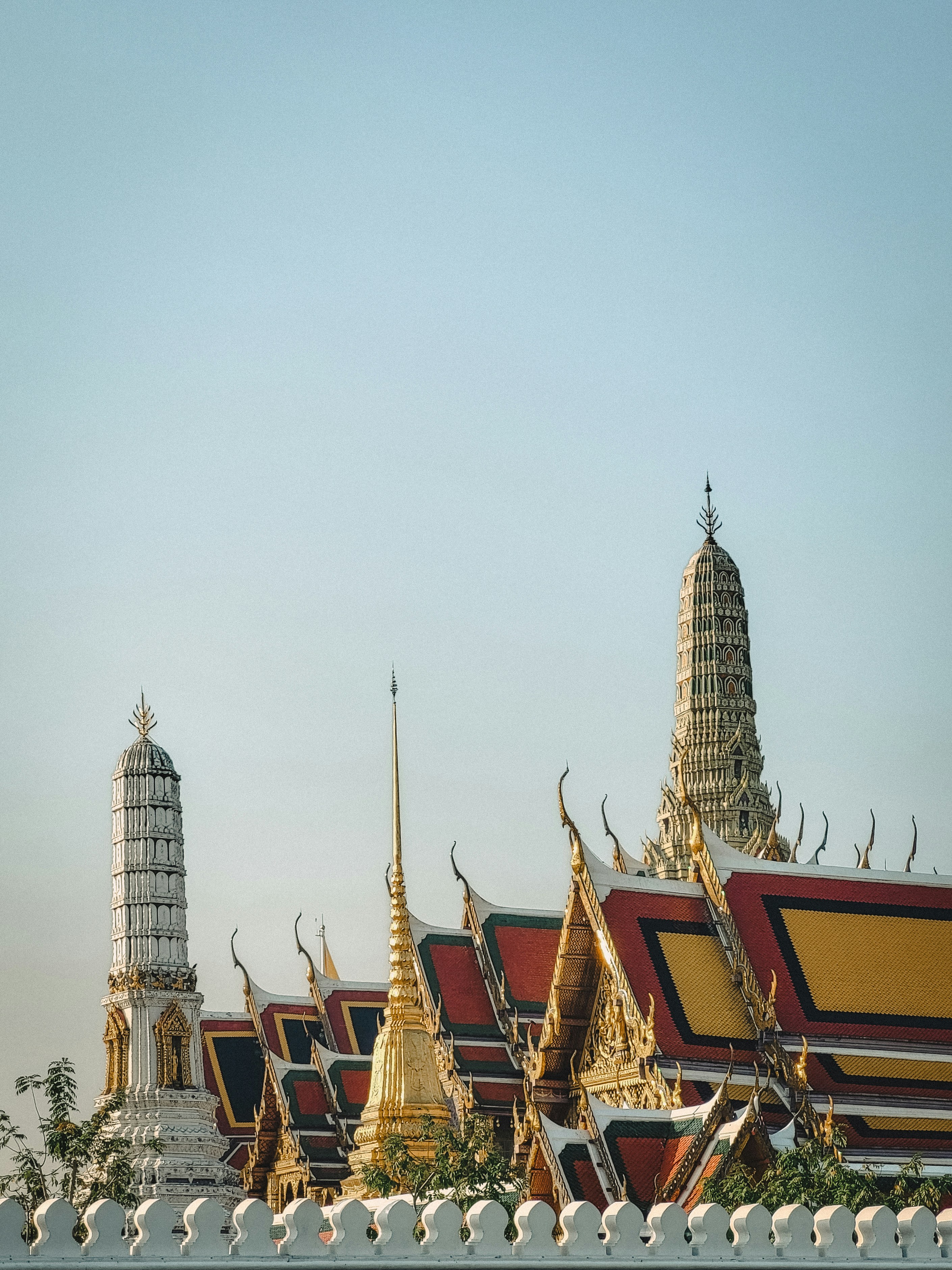 Ornate thai temple roofs against a clear sky