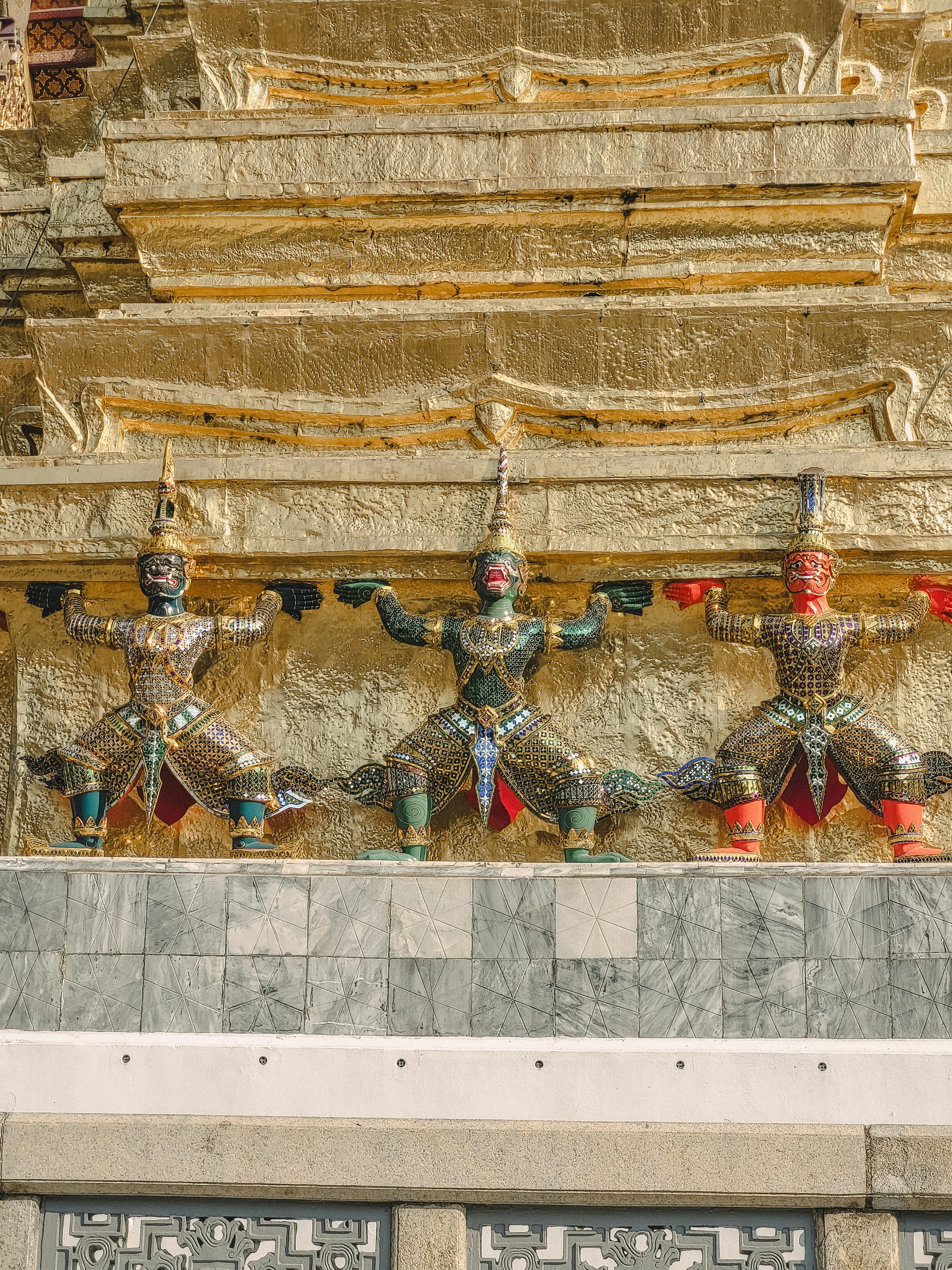 Three Armored Guardians Anchored on a Sunlit Temple Frieze