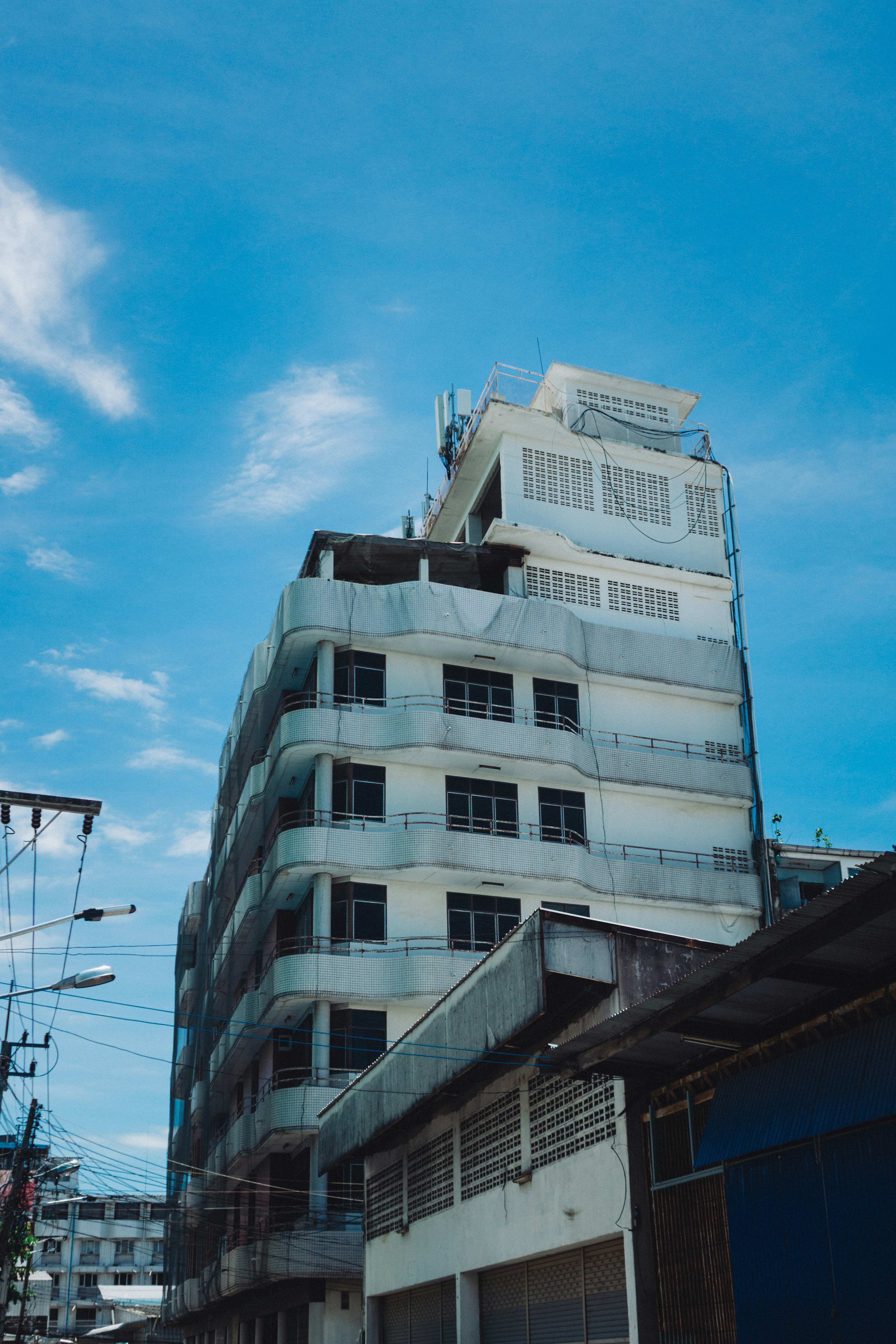 White building with balconies under a blue sky.
