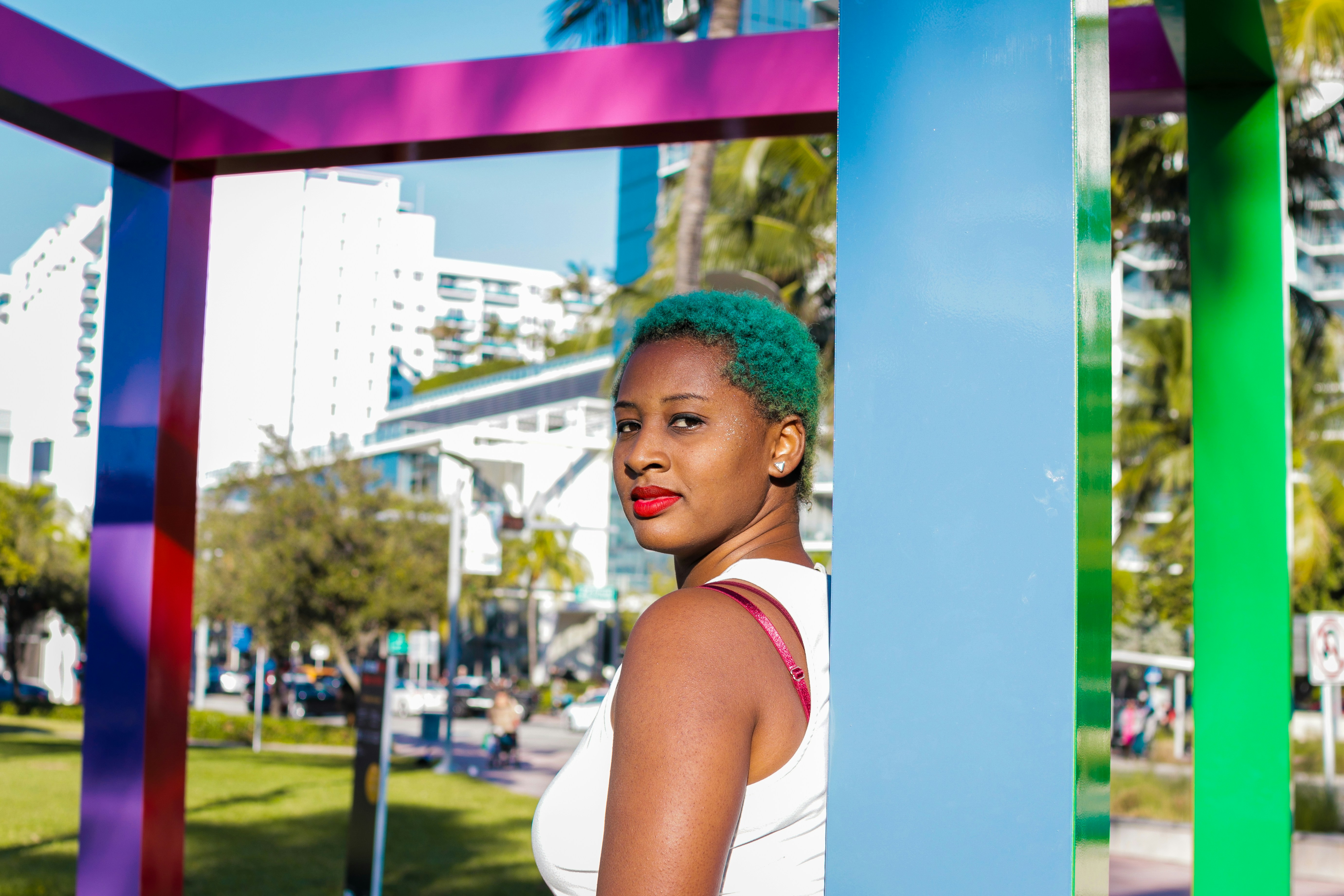 Miami state of mind | Woman with teal hair poses near colorful structure