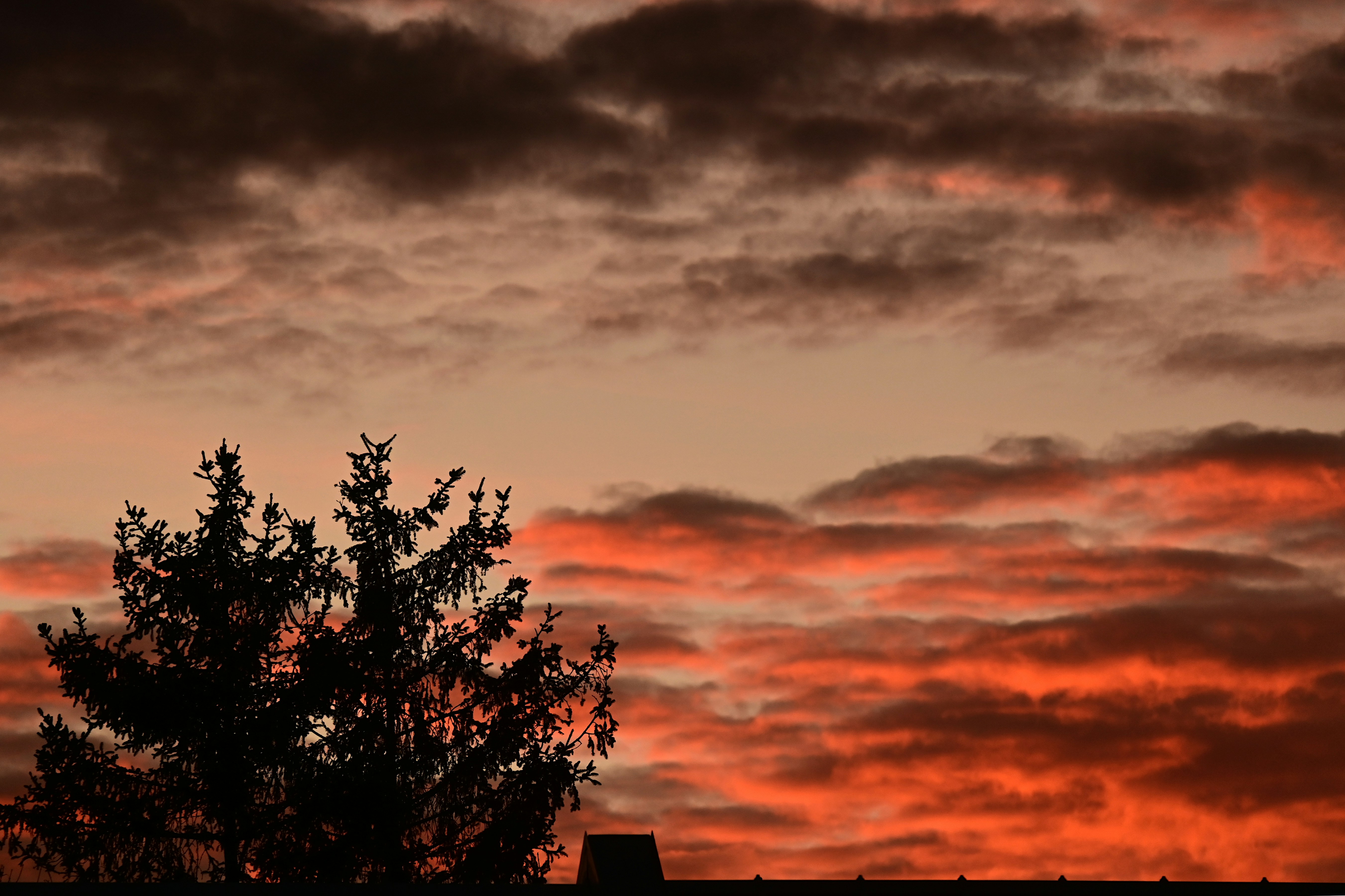 Dramatic fiery clouds at sunset over silhouette