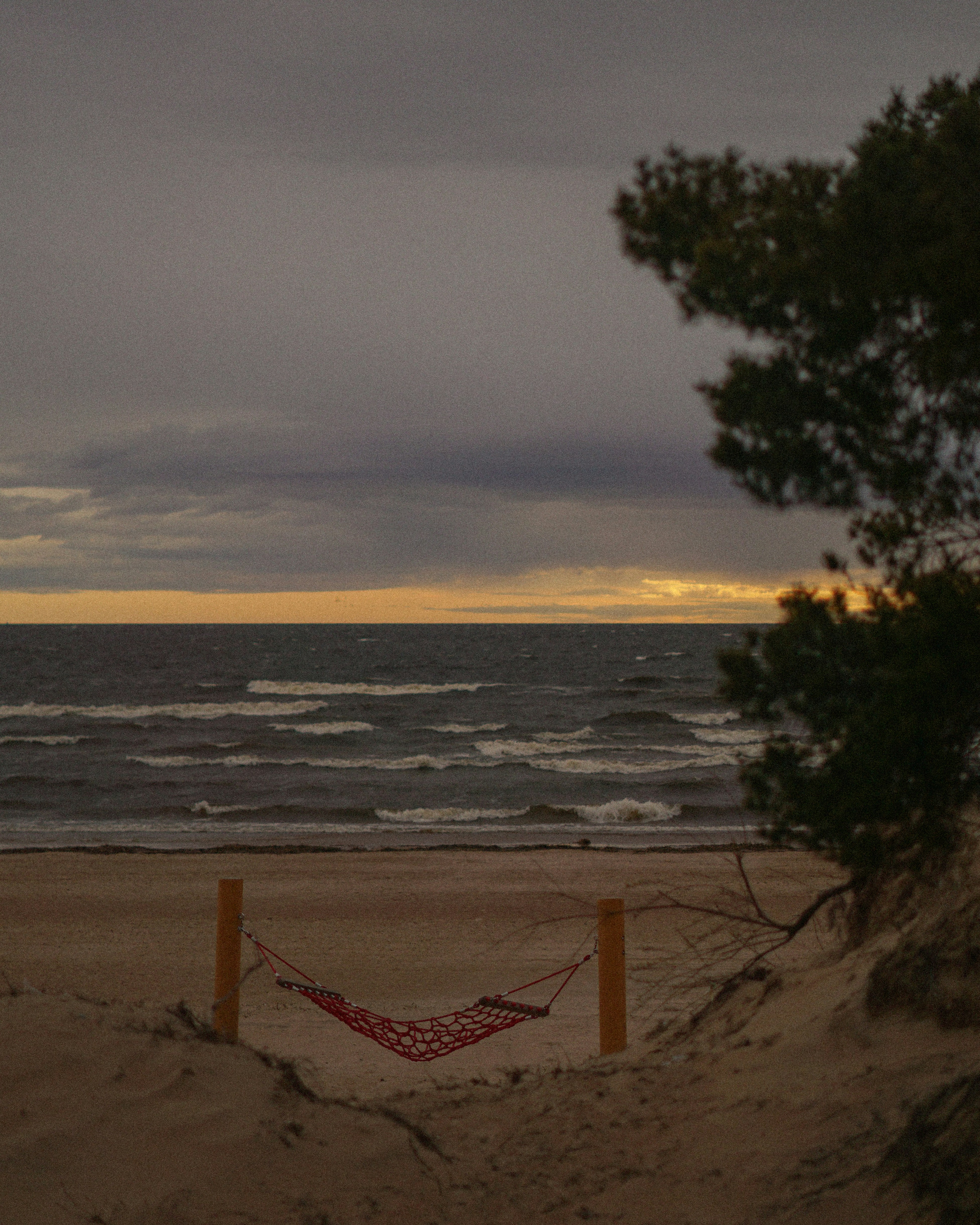 Hammock on a sandy beach near the ocean.