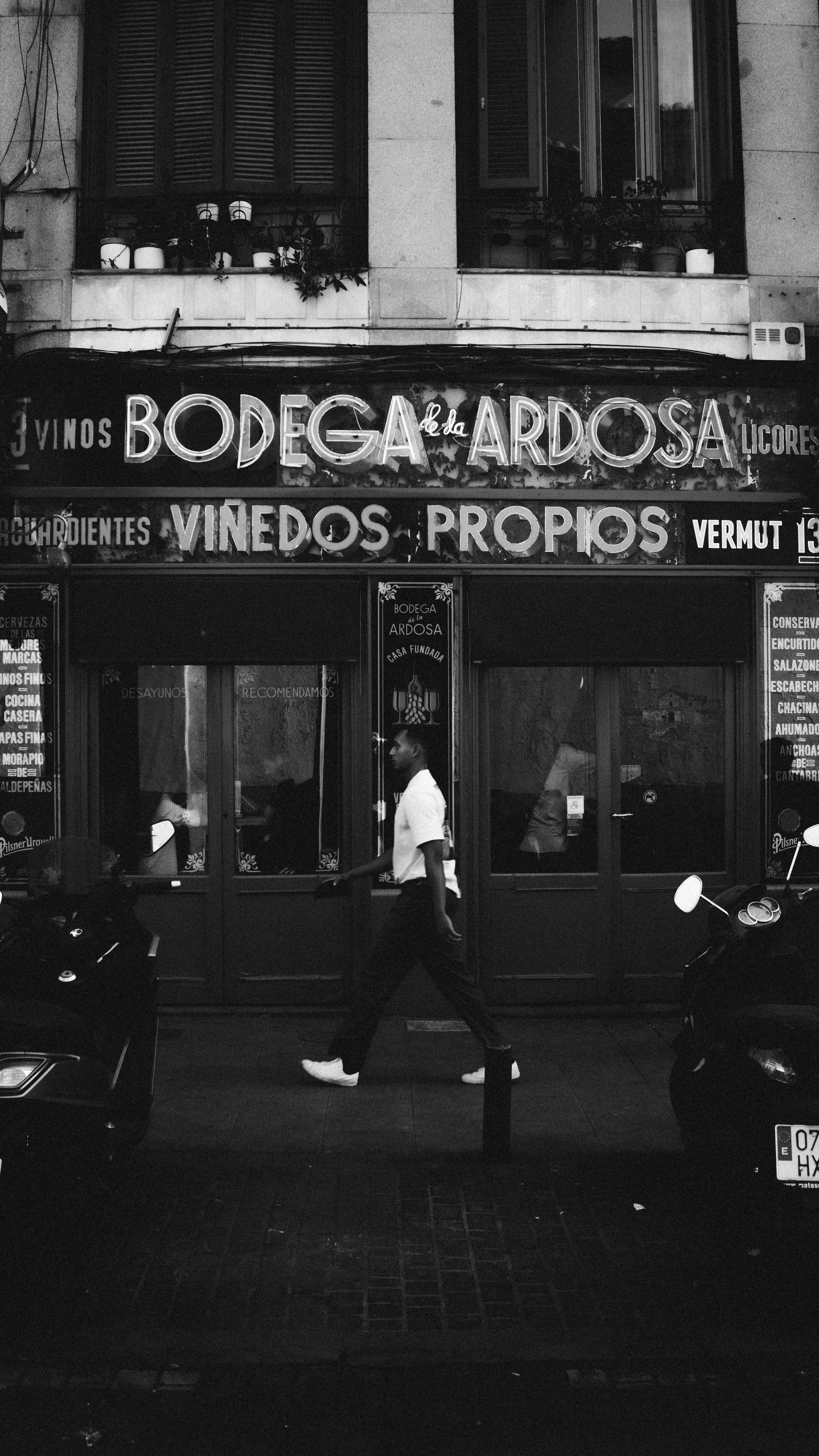 Madrid - Aug 2025 | Man walks past bodega ardosa storefront at night