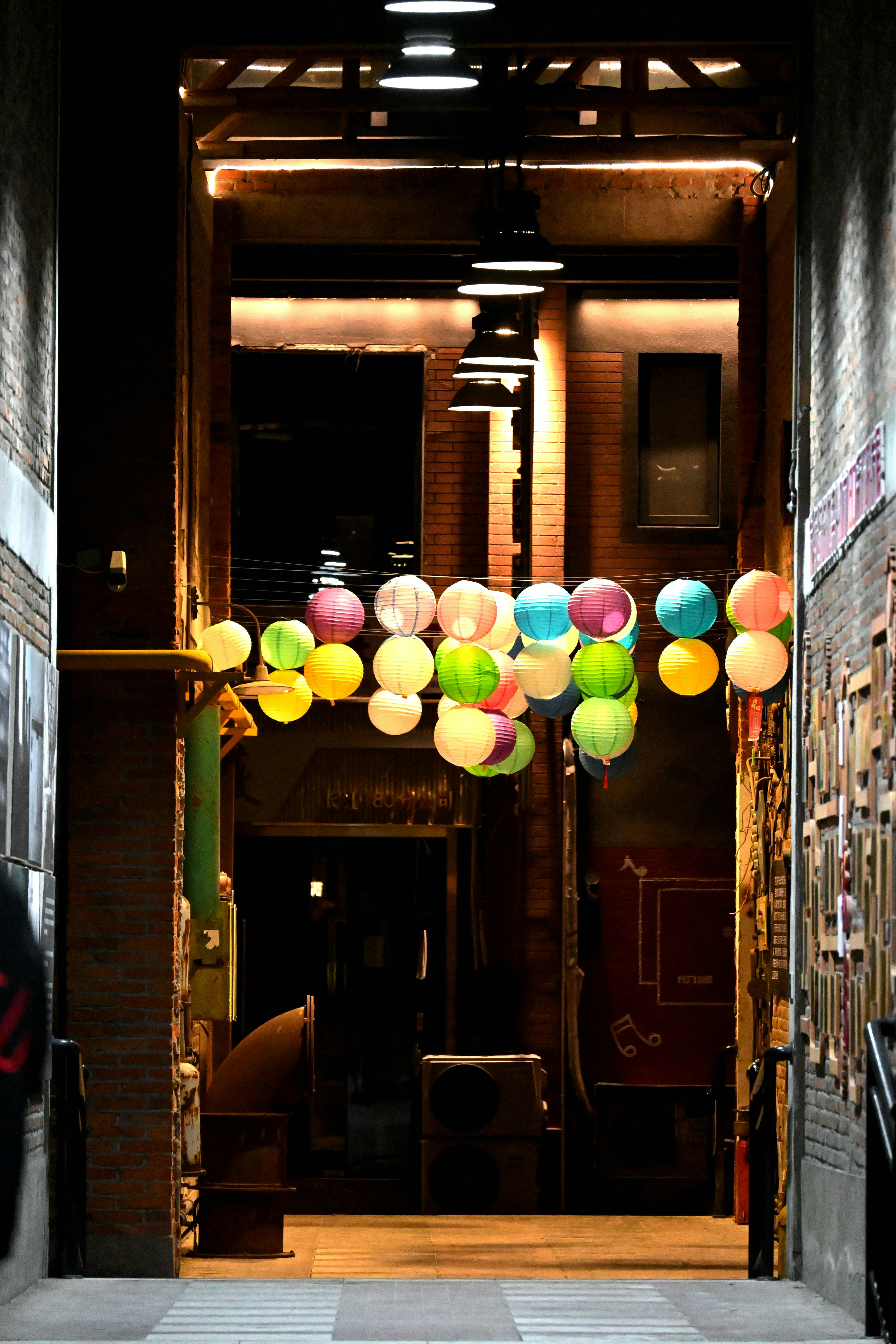 Colorful paper lanterns strung across a narrow alleyway.