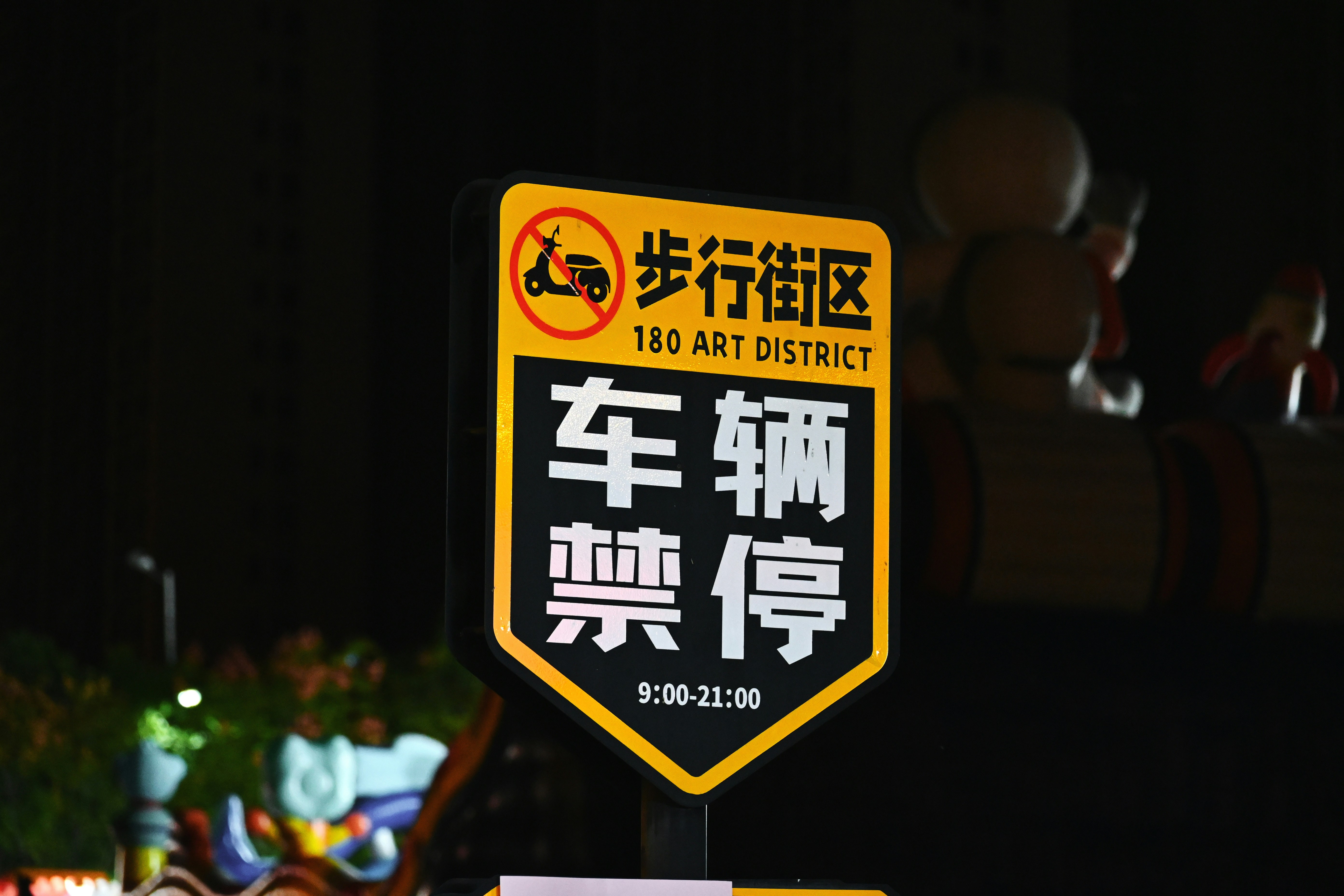 A sign in a pedestrian zone at night.
