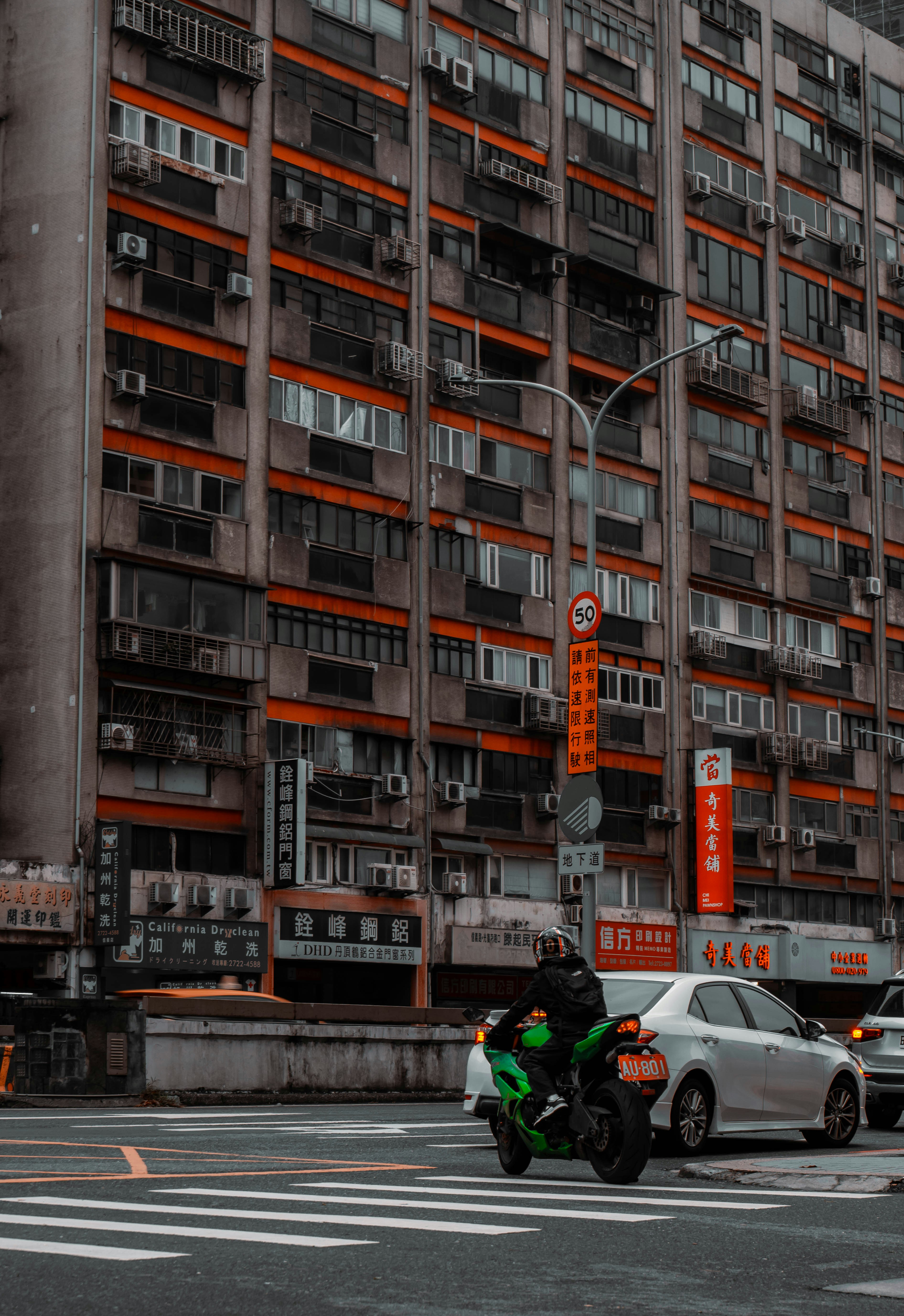 Motorcyclist at crosswalk with building background