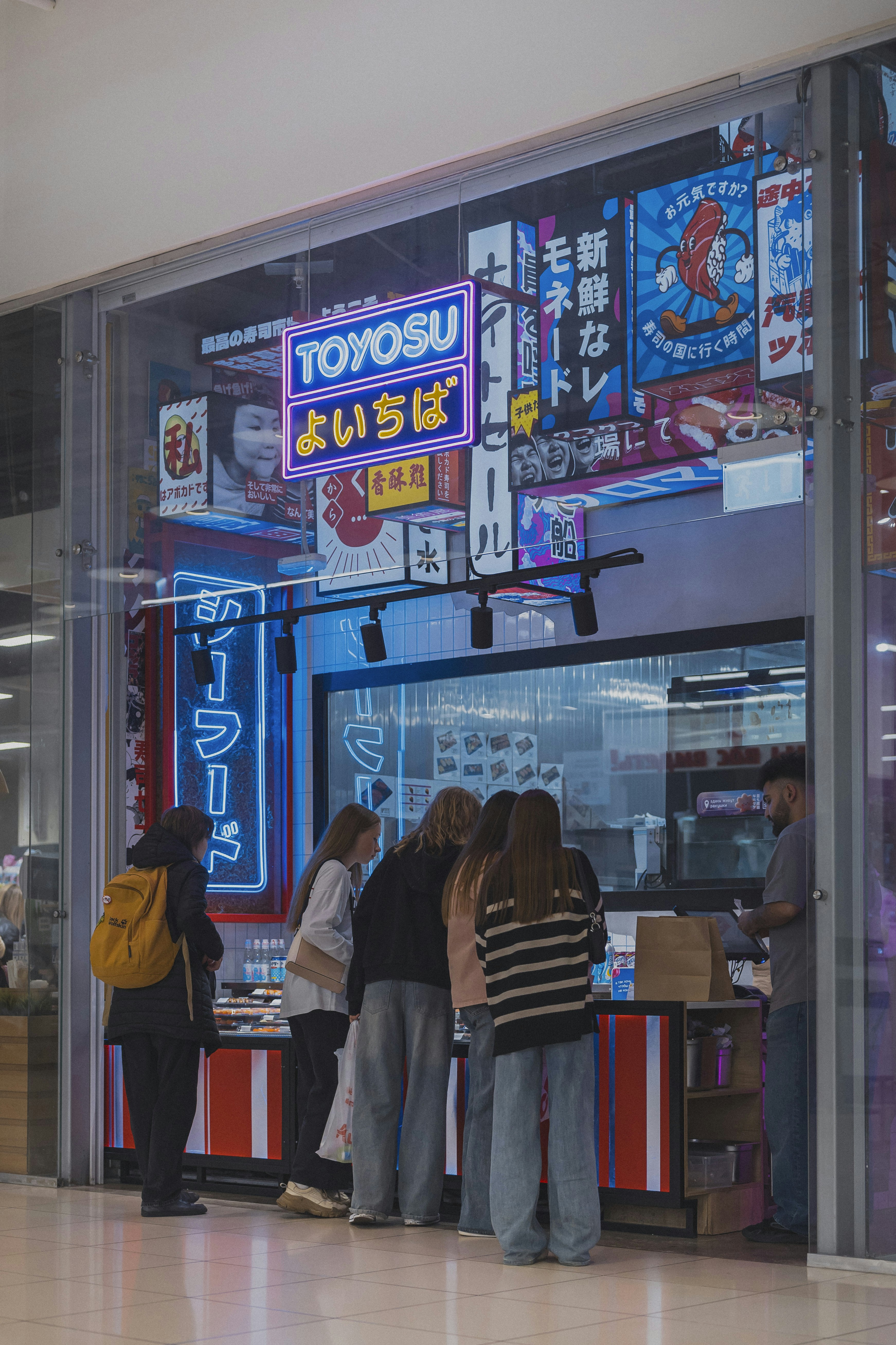 Neon Market: Tokyo Signage Illuminates a Food Stand Inside a Glass storefront