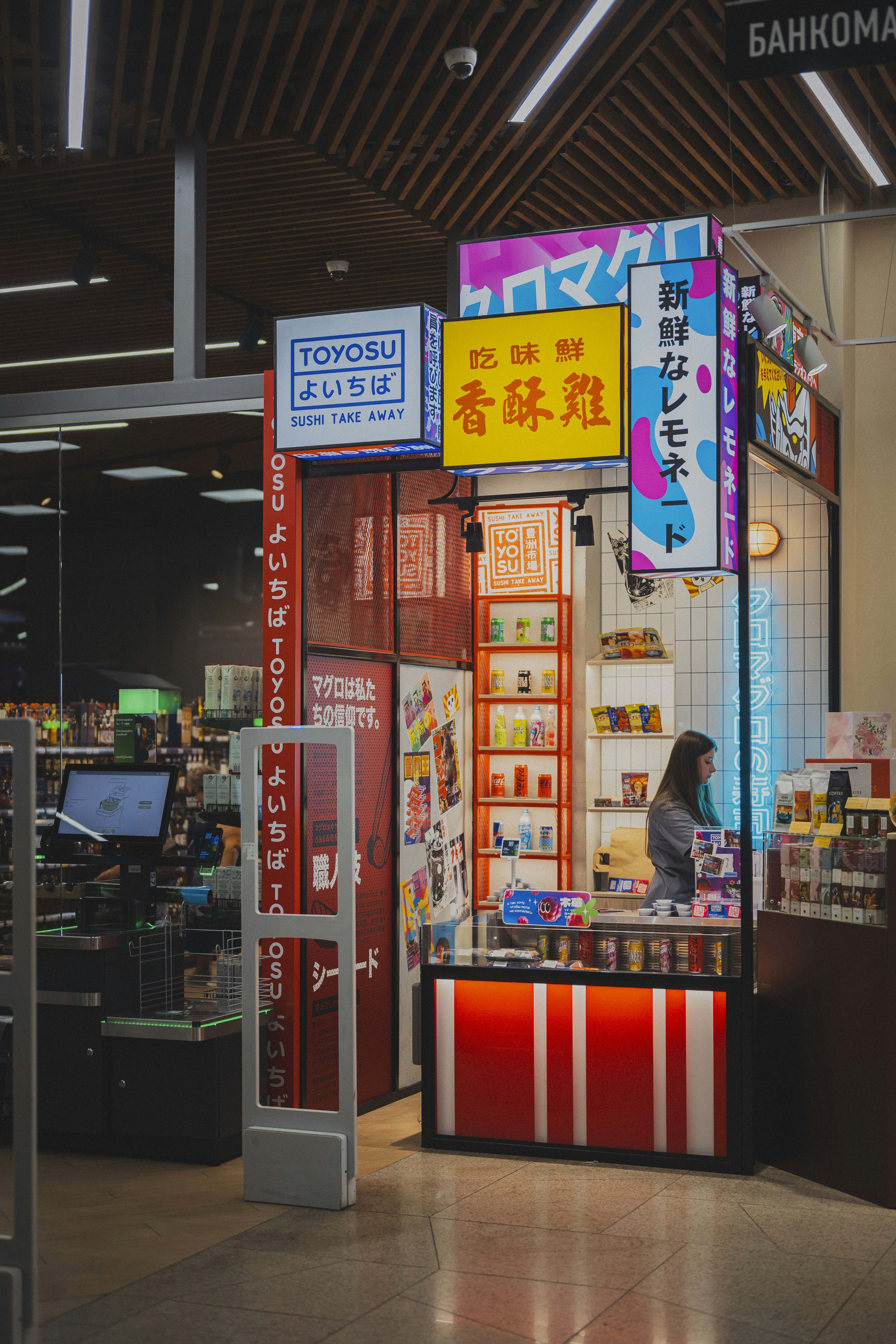 Neon Takes a Bite: A Sushi Takeaway Stall Under Mall Lights