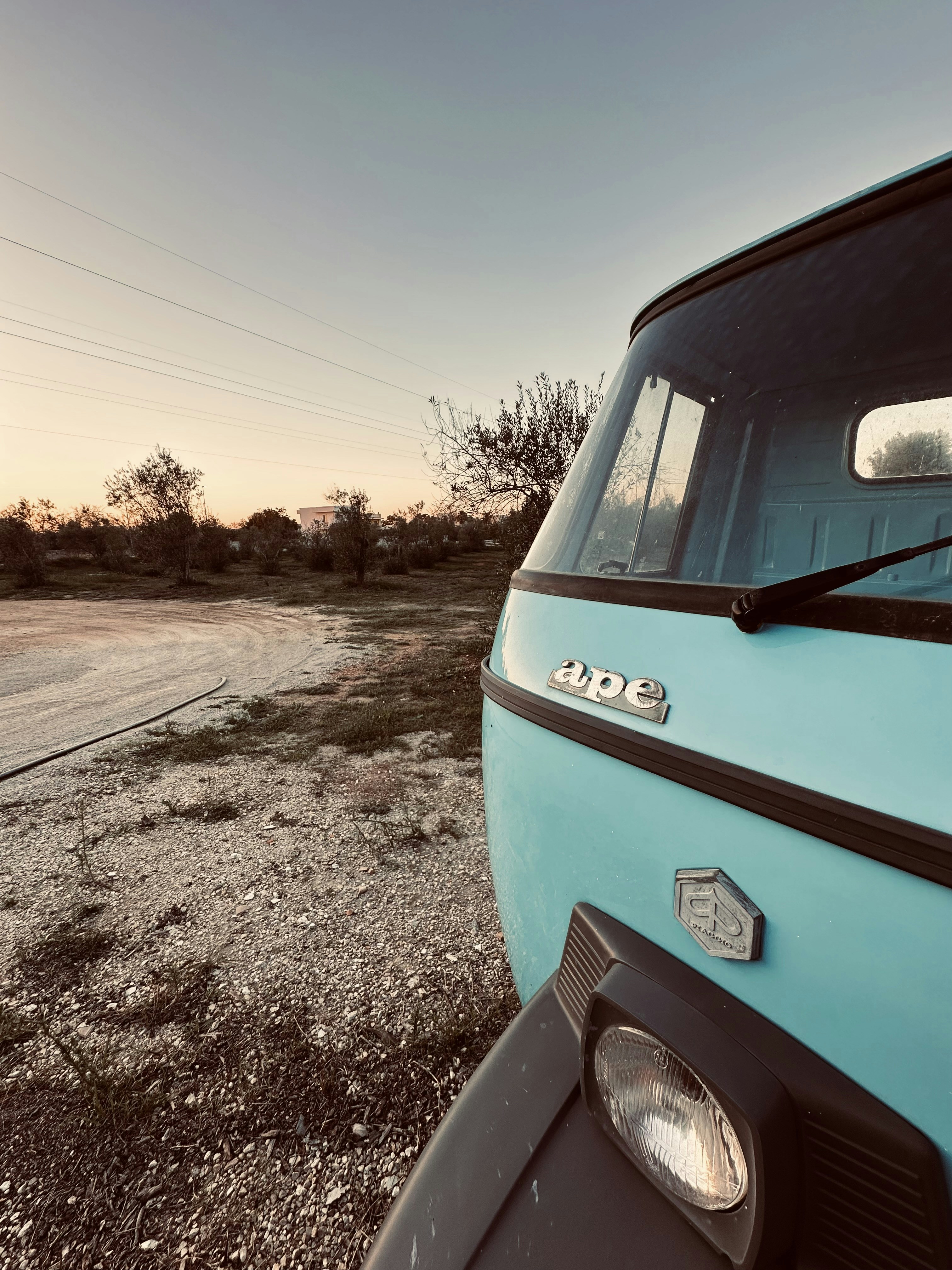 Turquoise three-wheeled vehicle at sunset