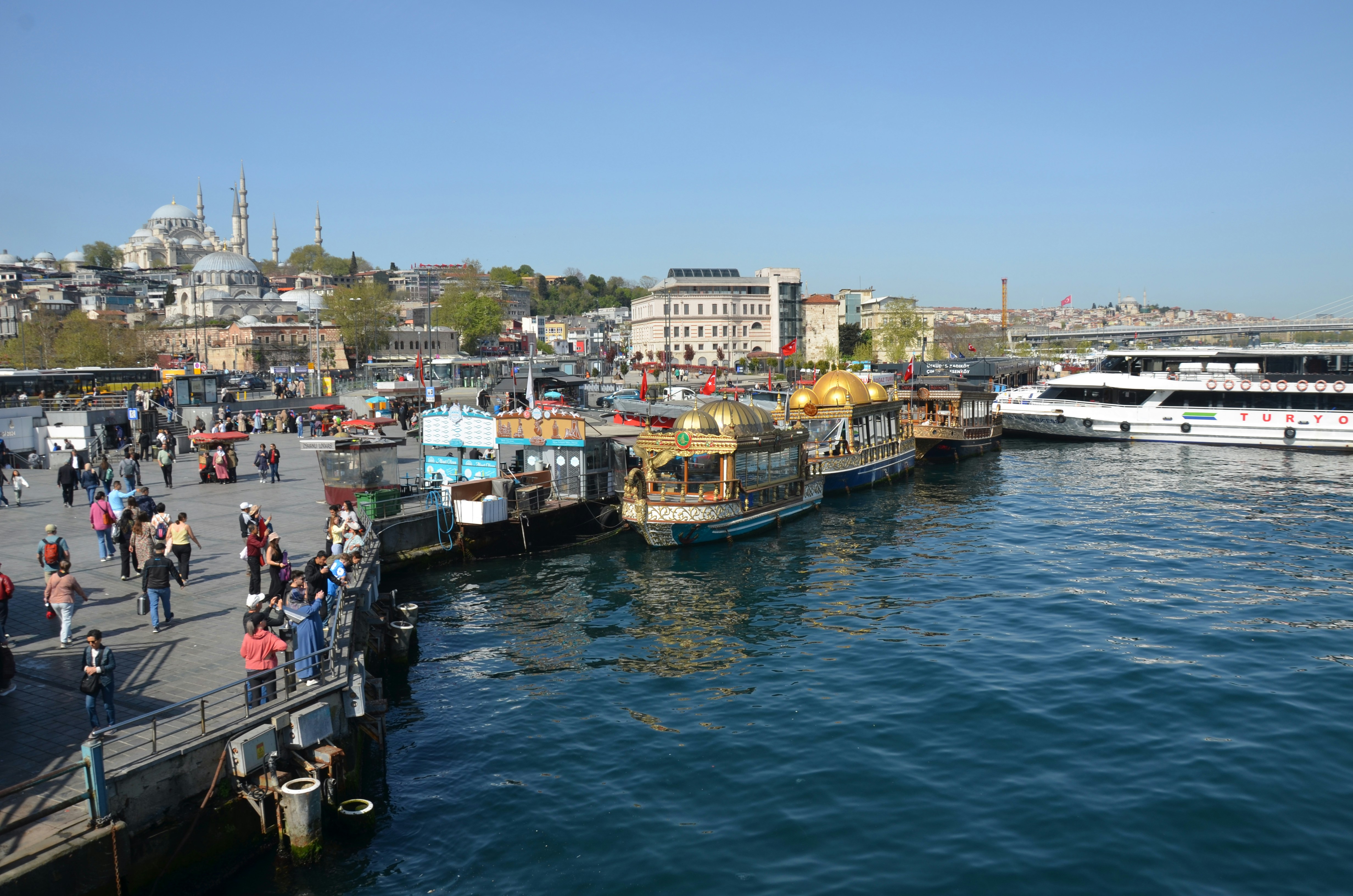 Boats docked at a busy harbor with city skyline
