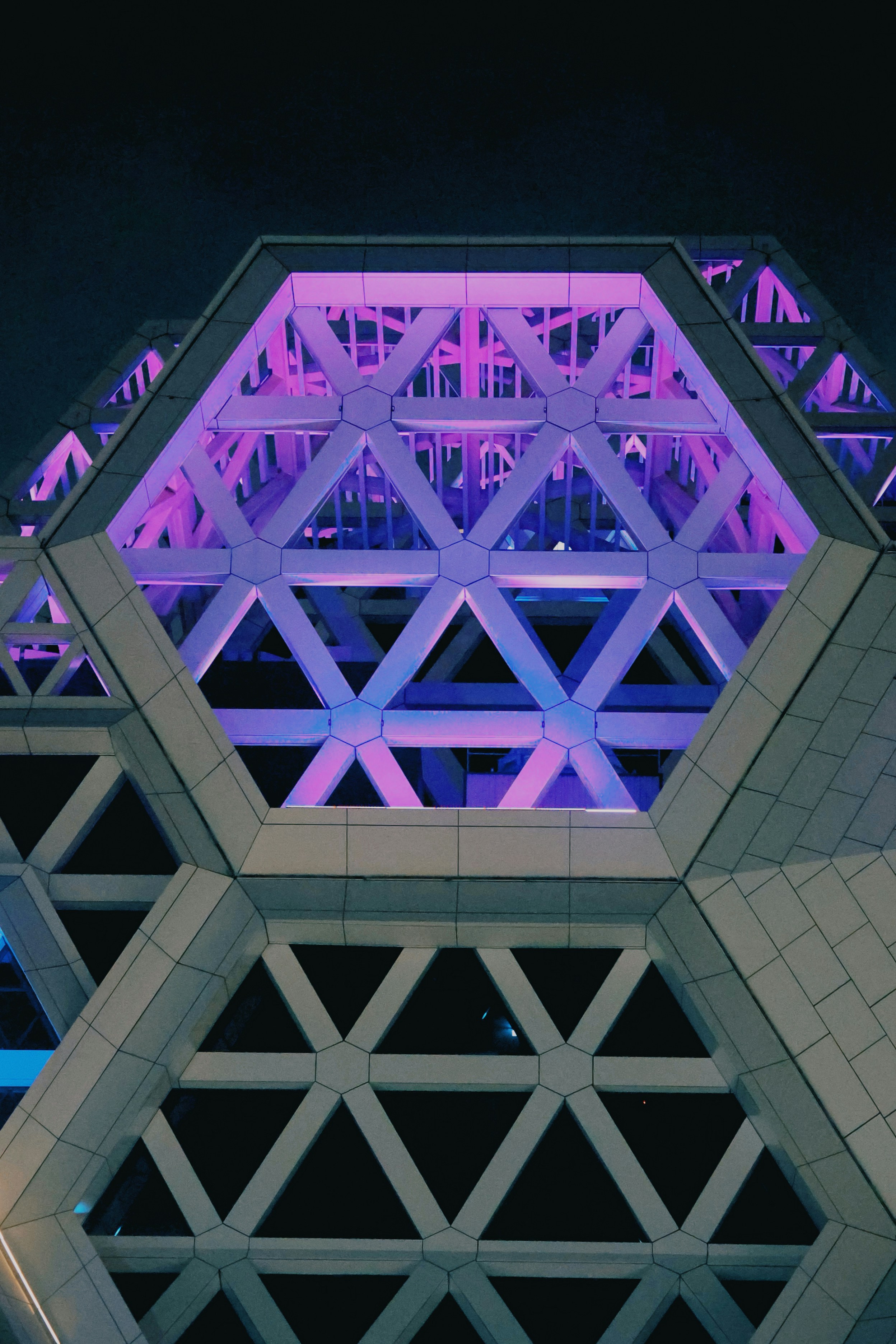 Kaohsiung Music Center | Geometric building illuminated with purple and blue lights.