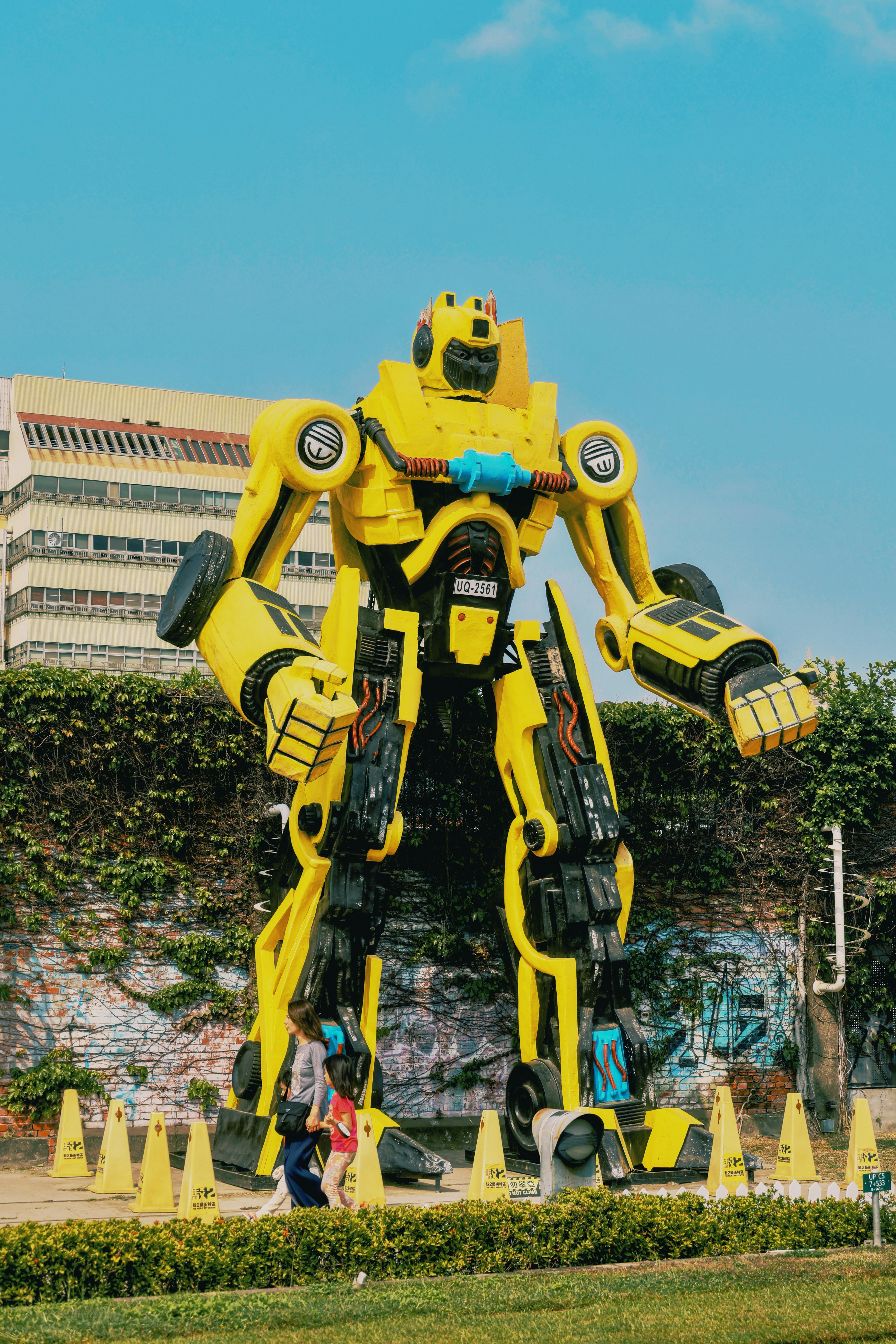 Giant yellow robot sculpture against blue sky