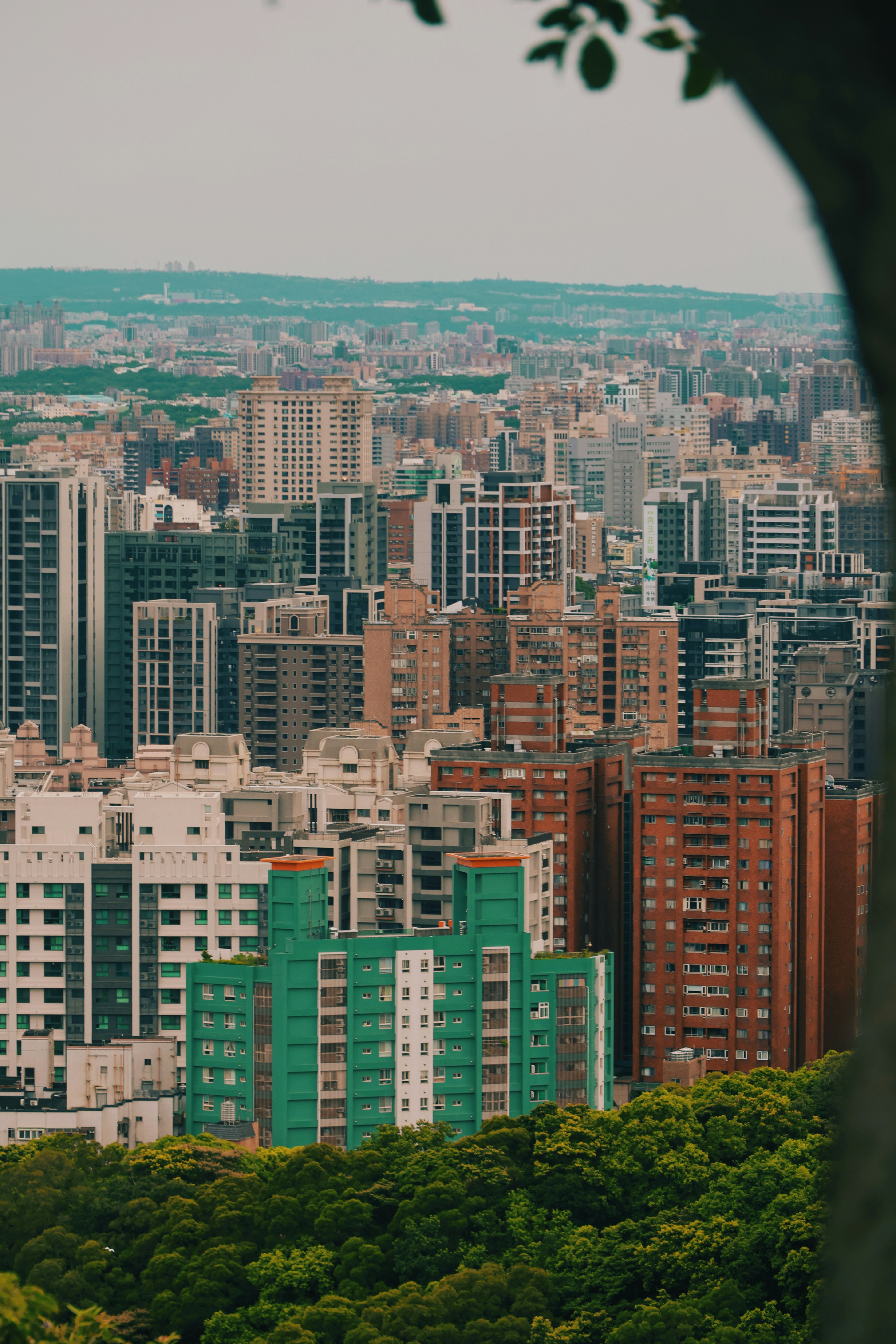Expansive cityscape with diverse buildings and lush greenery.