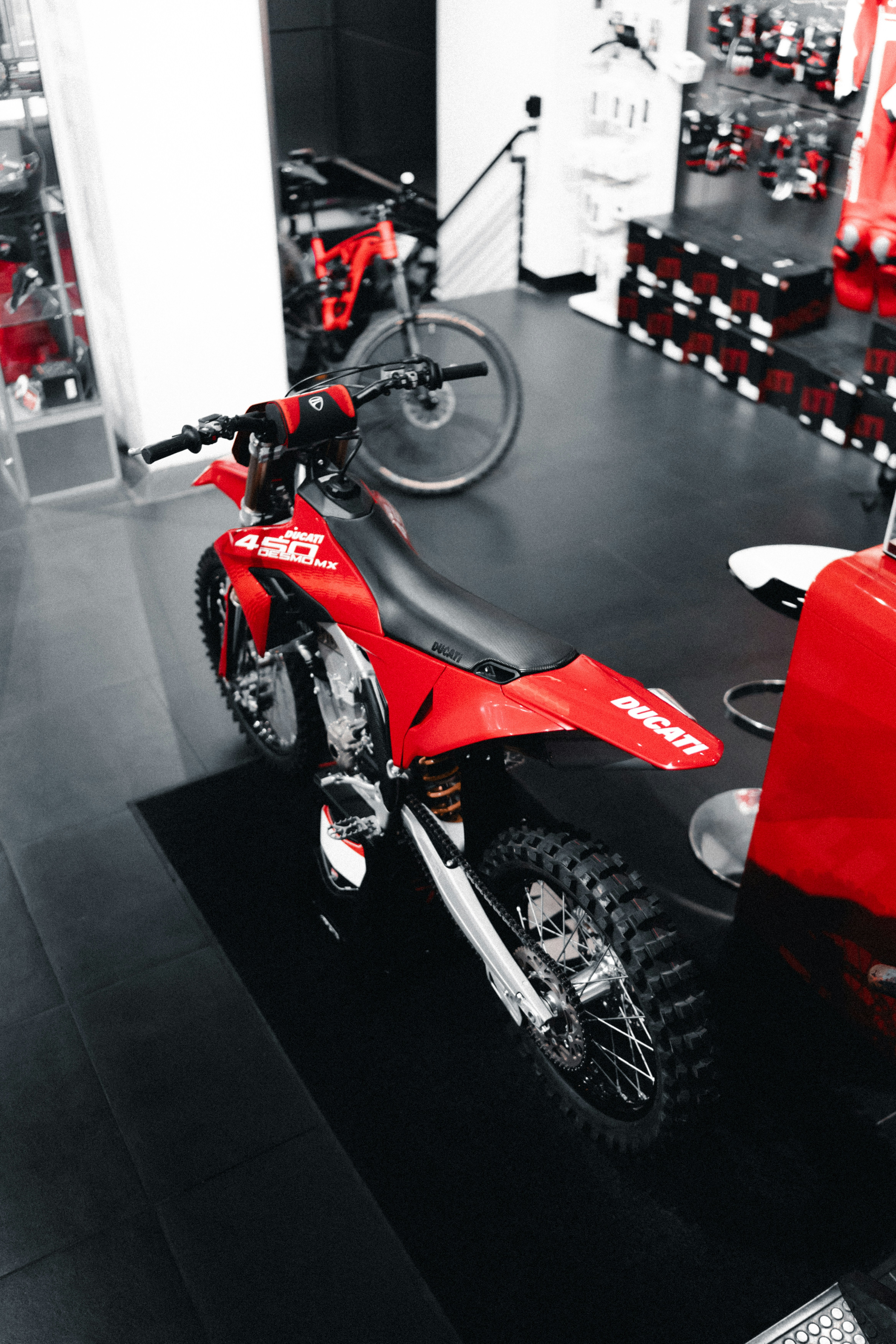 Red dirt bike on display in a showroom.