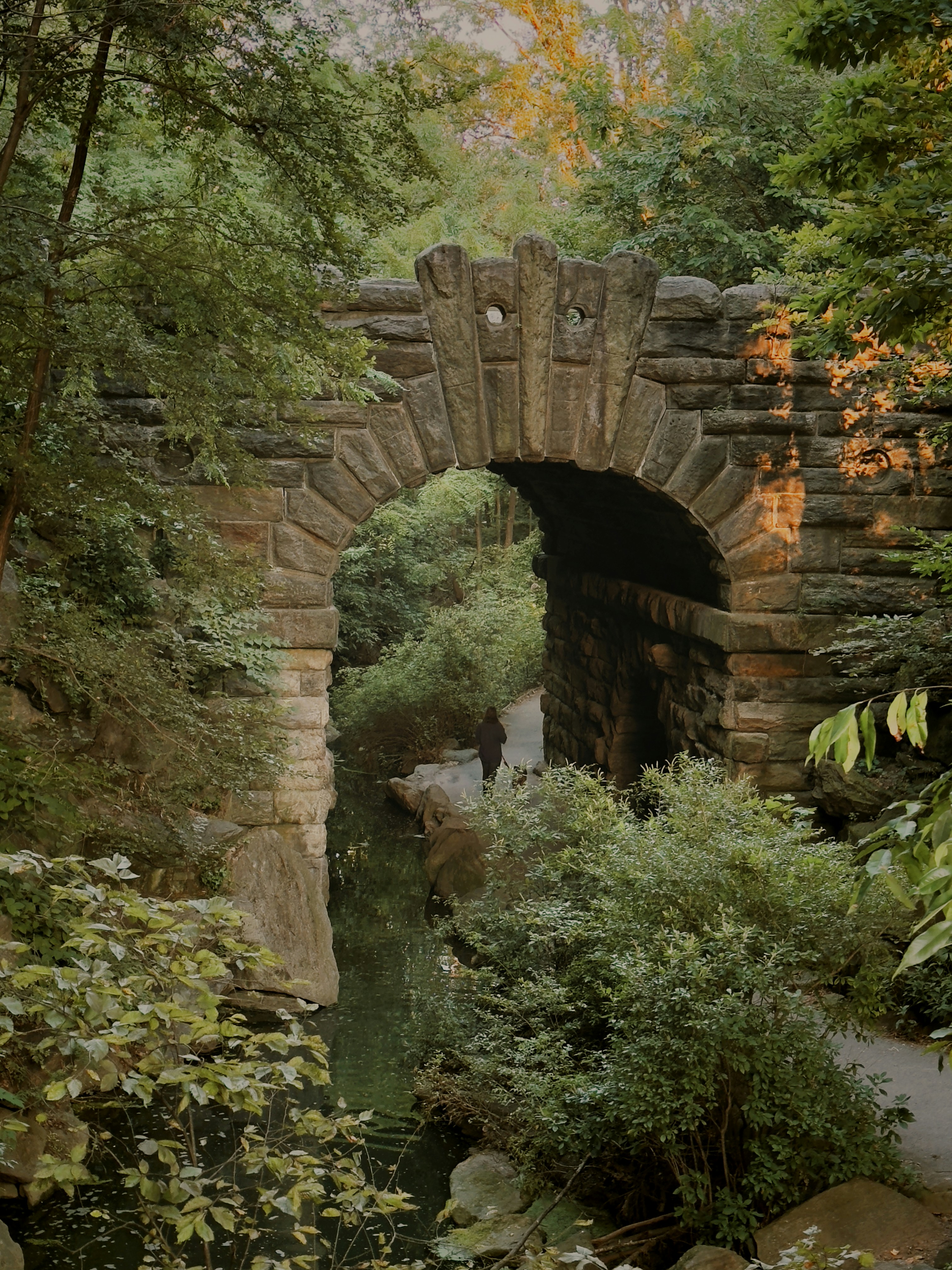Created with RNI Films app. Profile 'Agfa Optima 200 Warm' | Stone bridge over a stream in a lush park.
