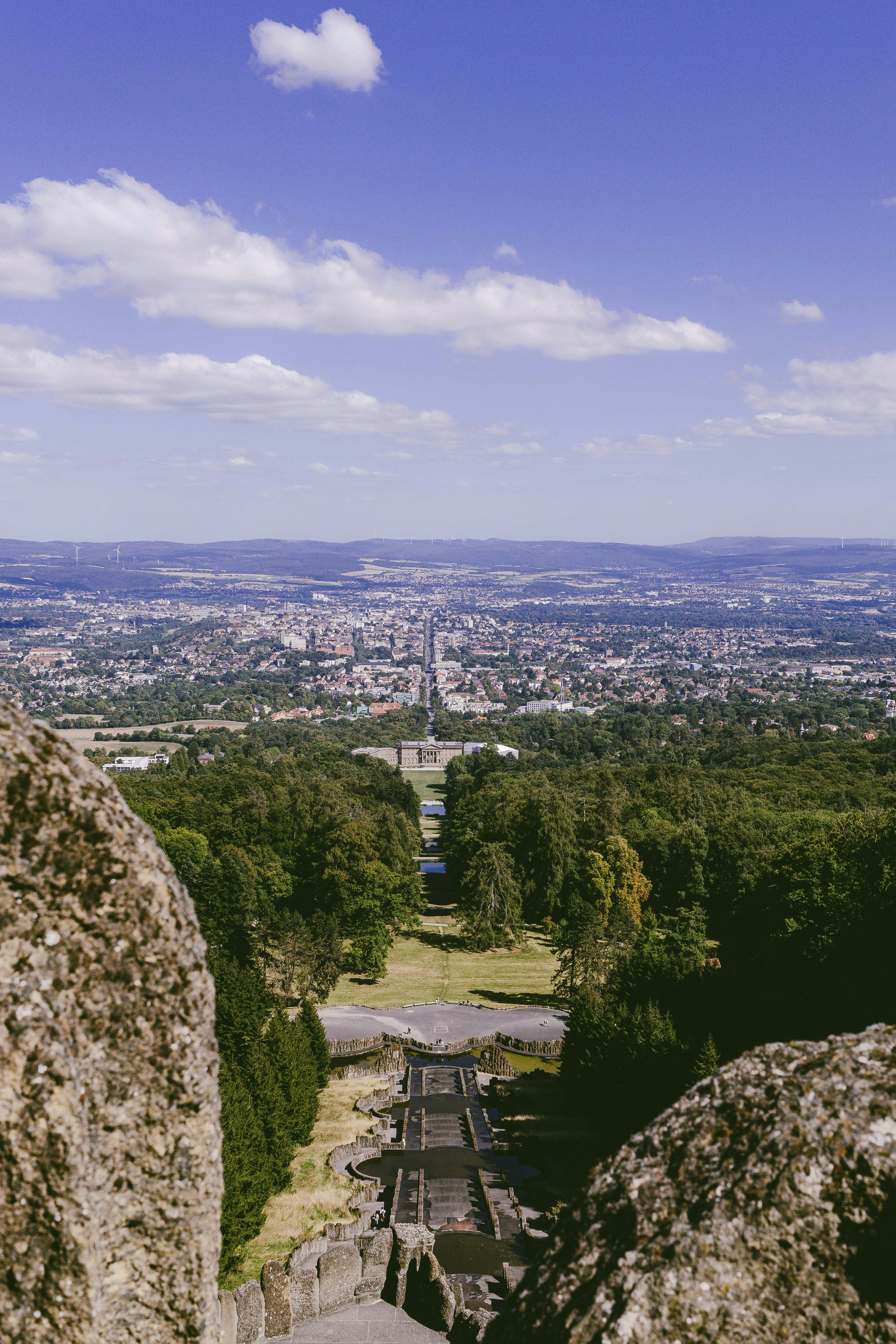 Panoramic view of a city and park from a hilltop.