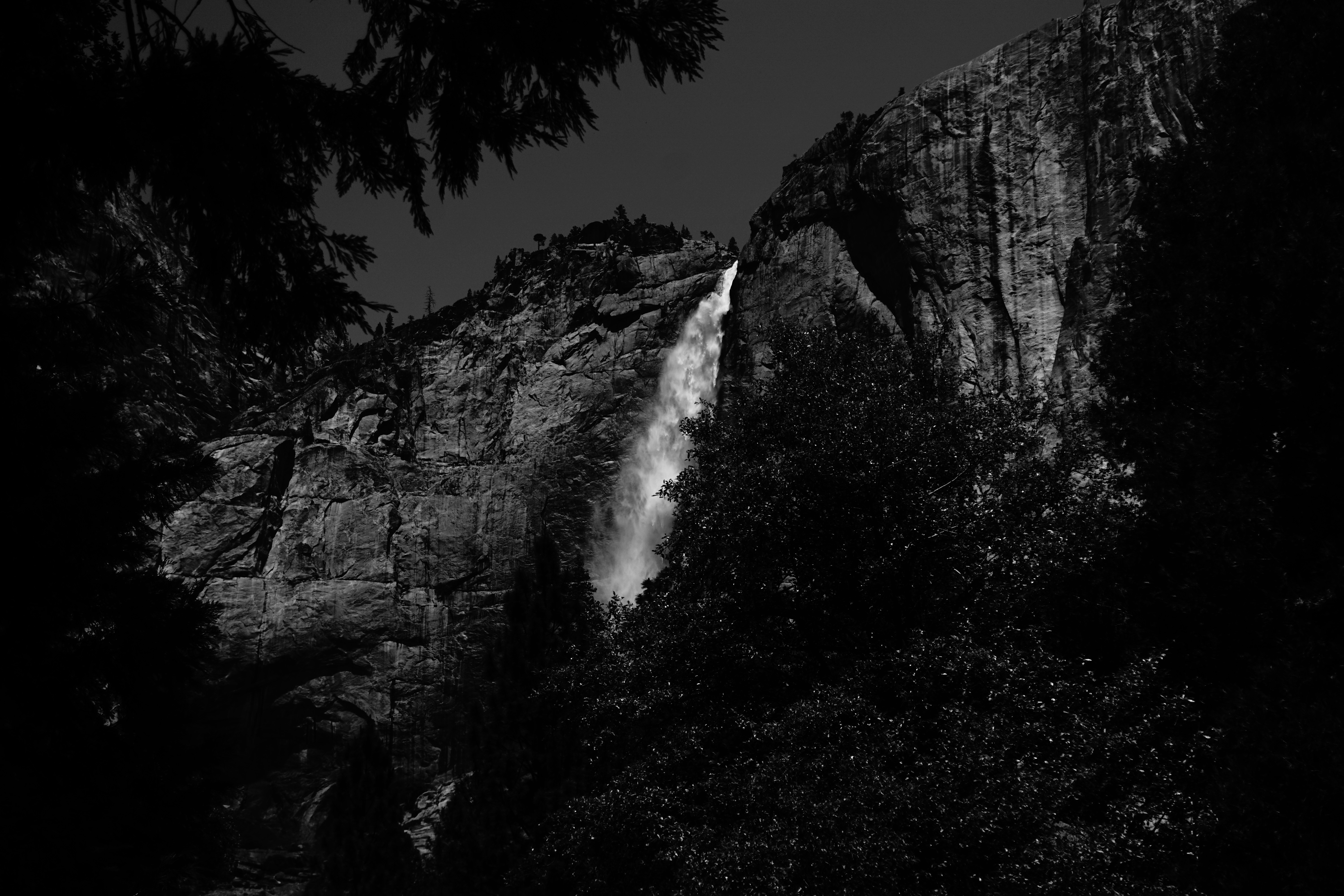Waterfall in Yosemite Valley (Black and White) | Waterfall cascading down a rocky cliff face.