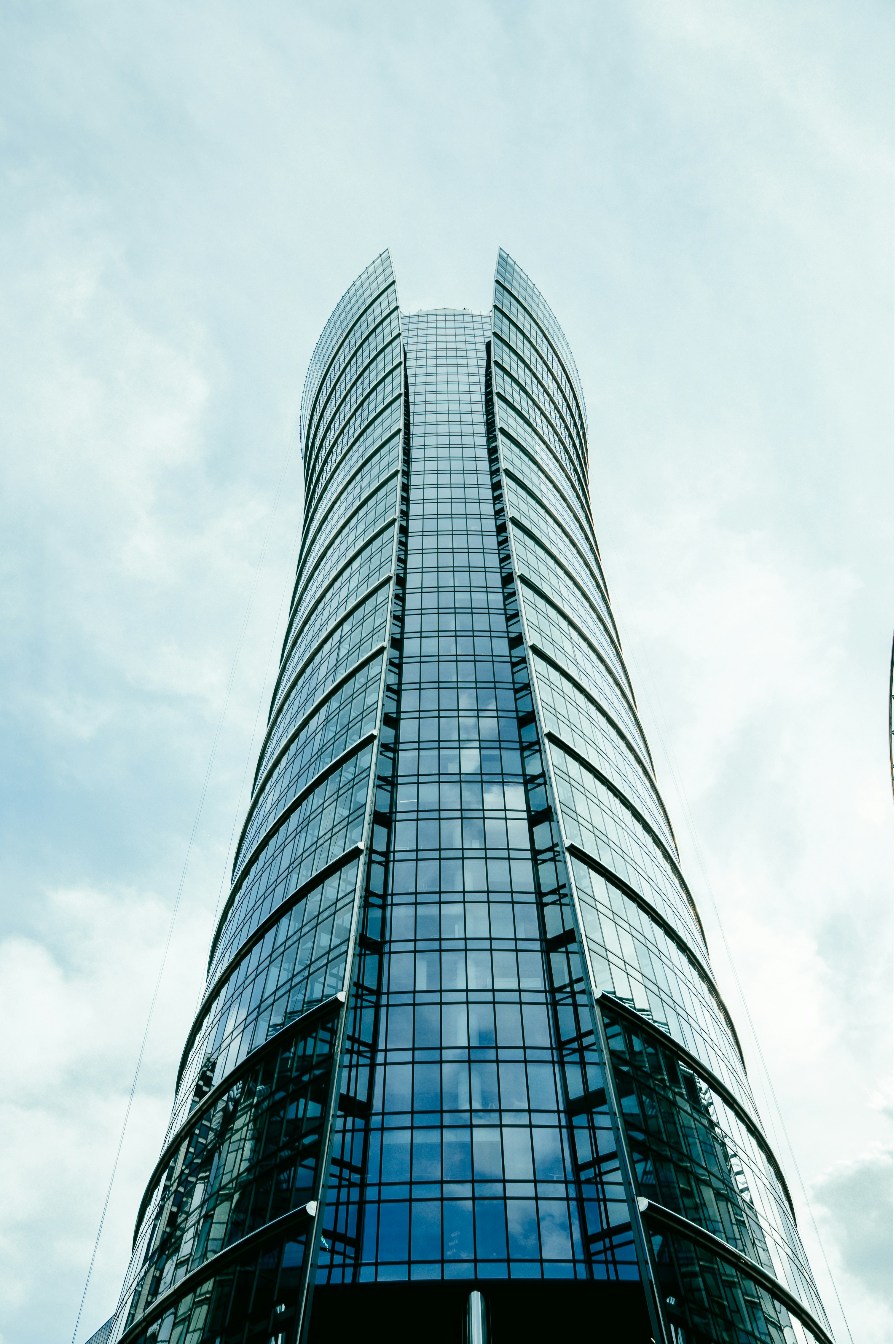 Modern glass skyscraper against a cloudy sky