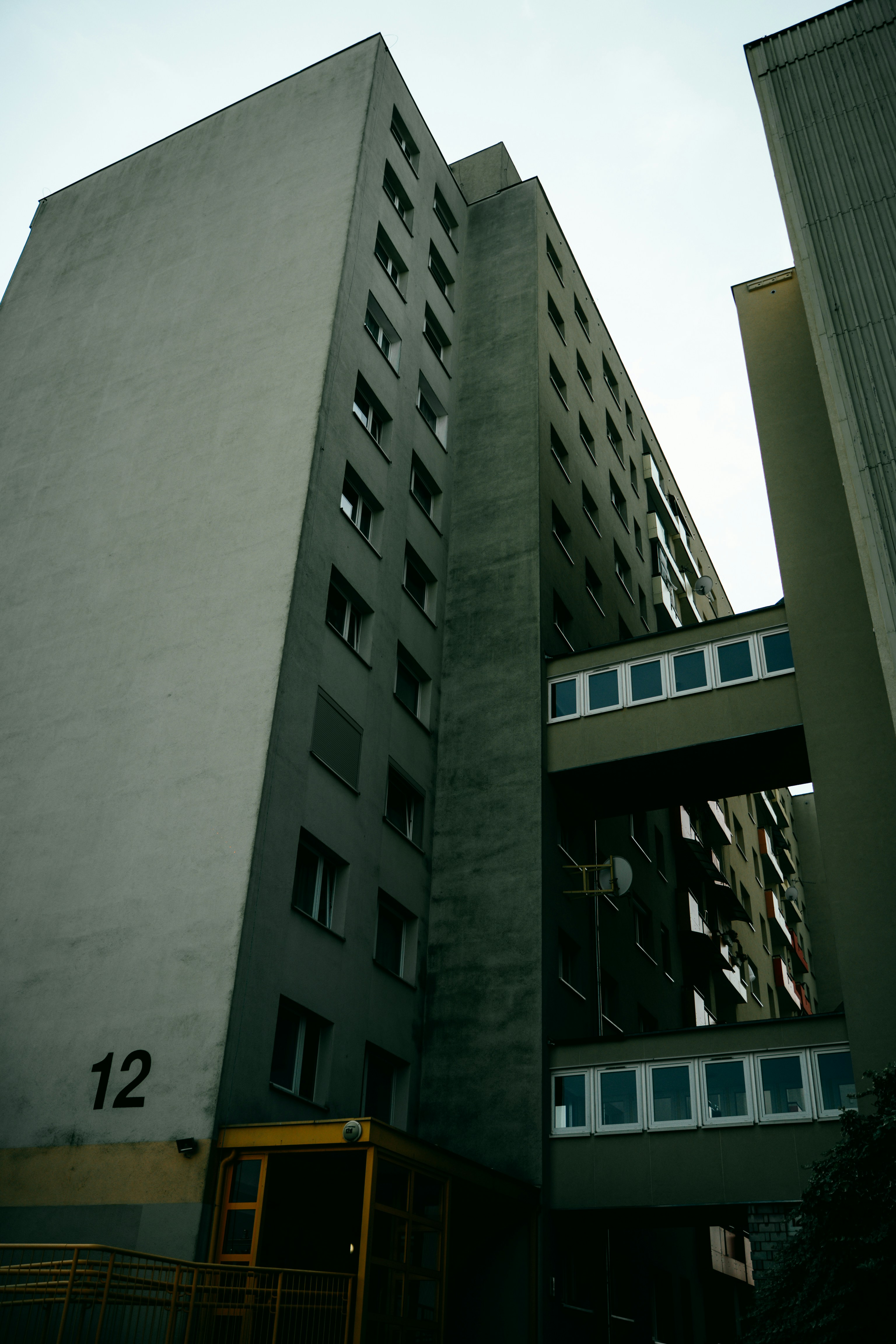 Tall, grey apartment building with connecting skybridge