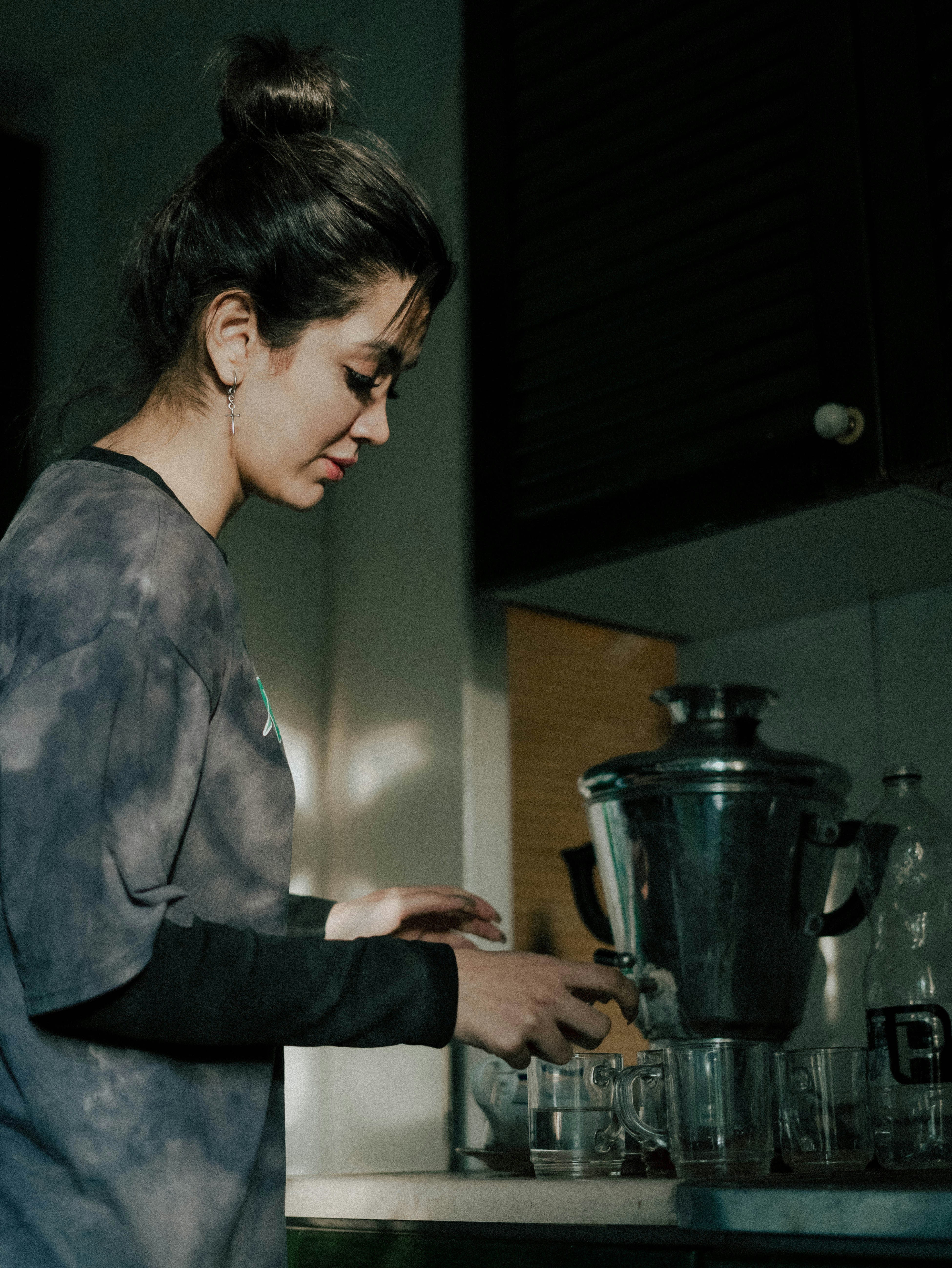 Woman pouring water from a coffee maker