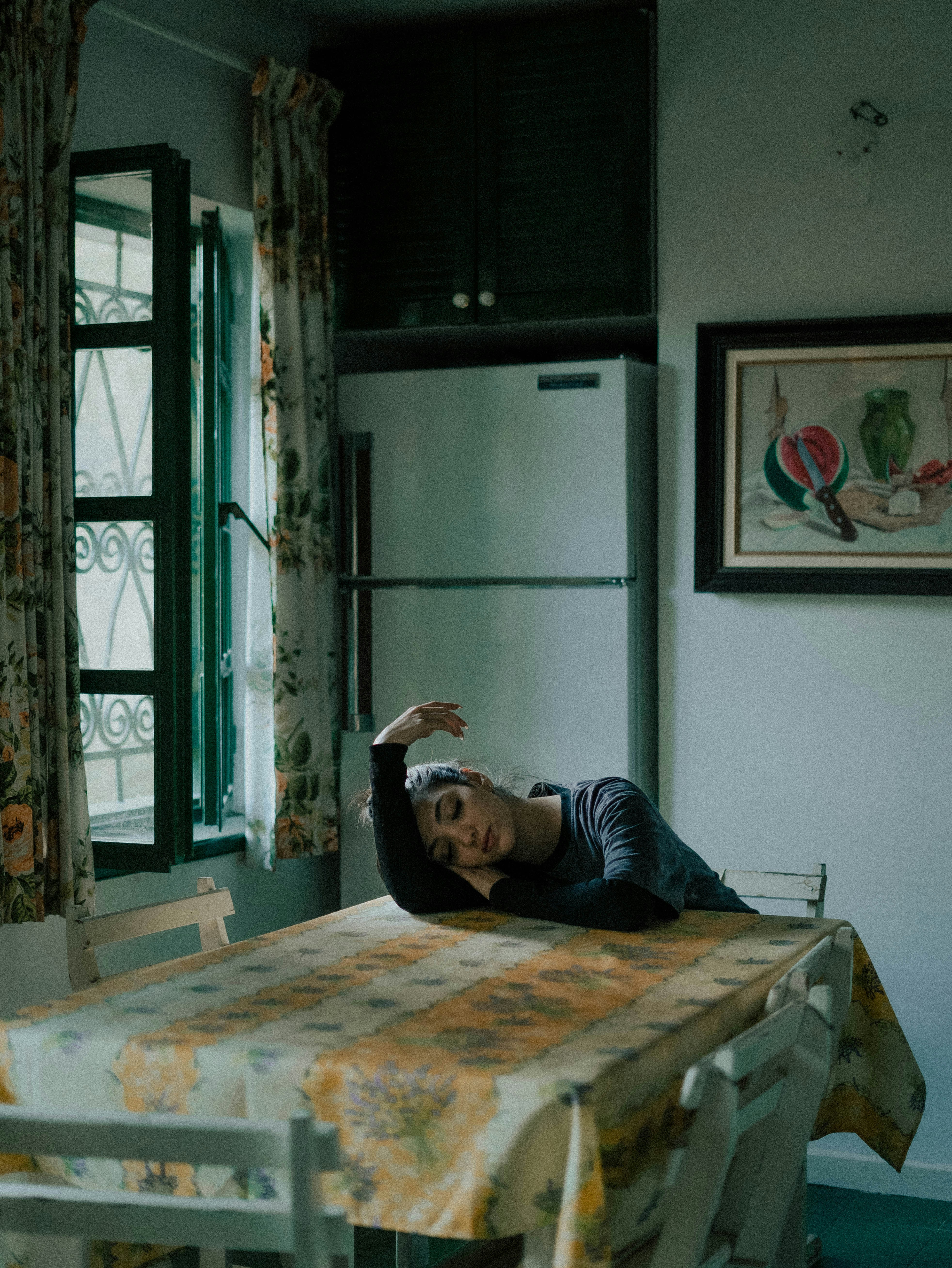 Woman resting head on table in dimly lit room photo – Free Man Image on ...