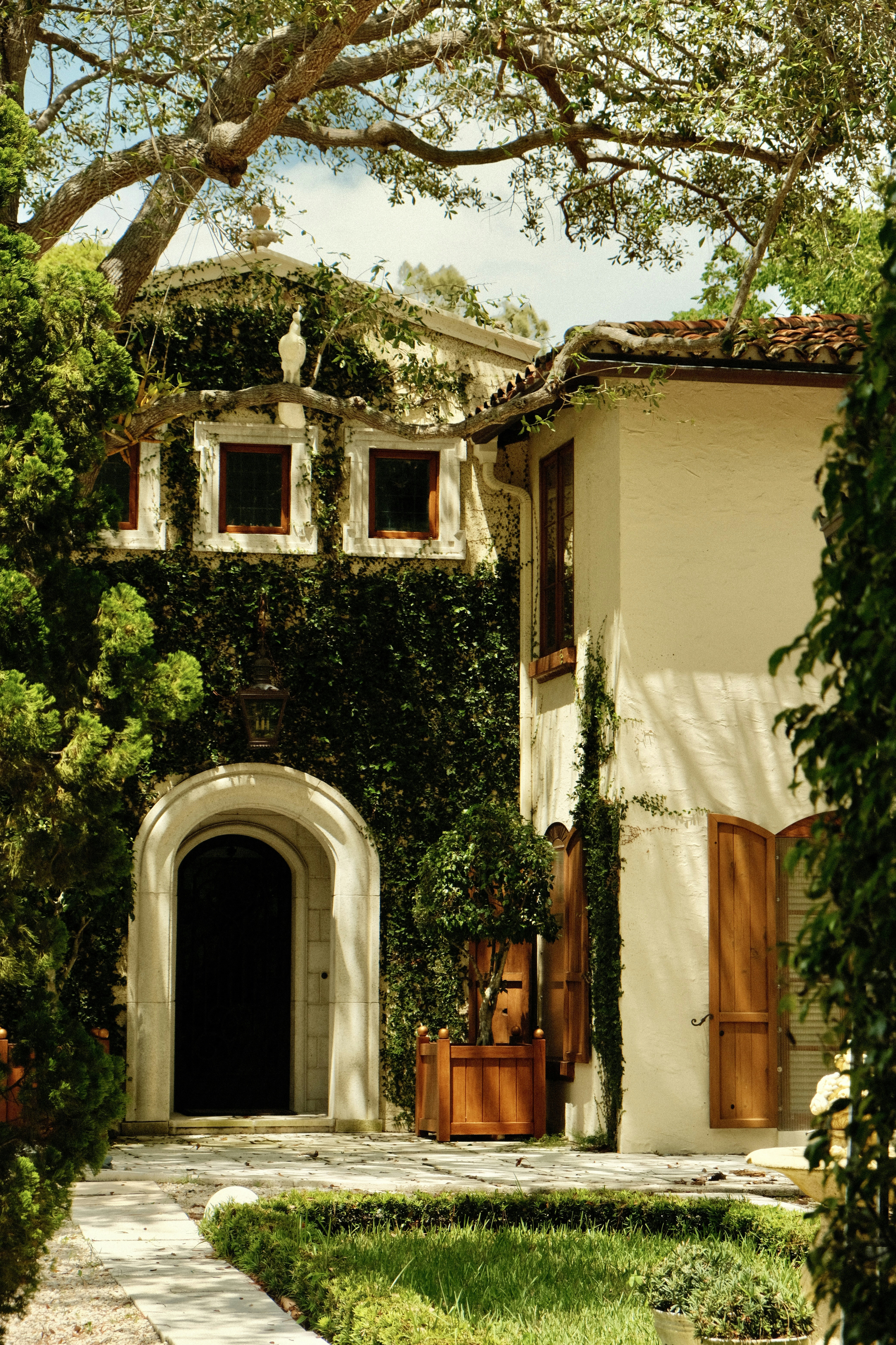 Mediterranean villa entrance with lush greenery and arched doorway