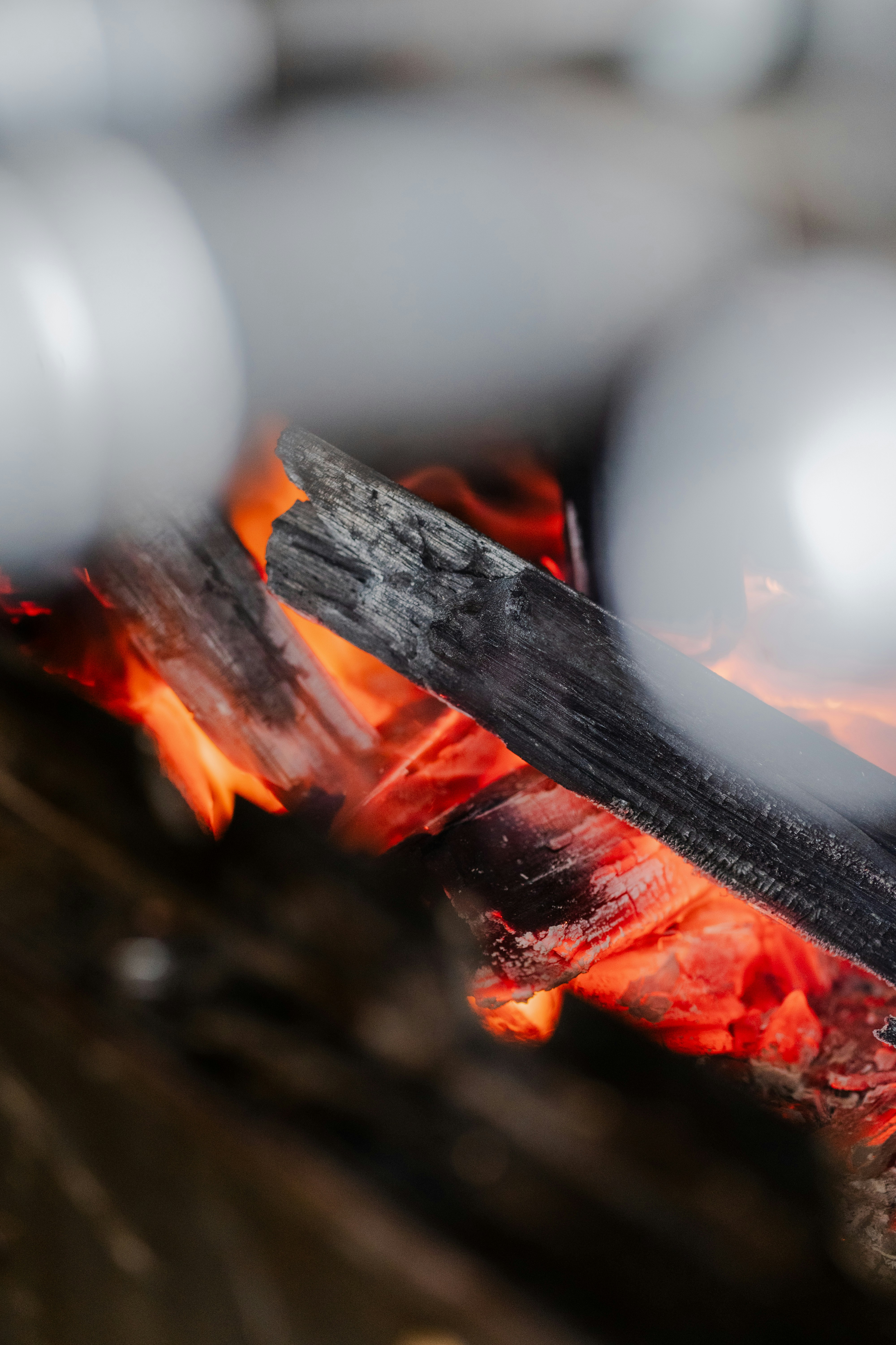 Glowing embers and burning wood with smoke.