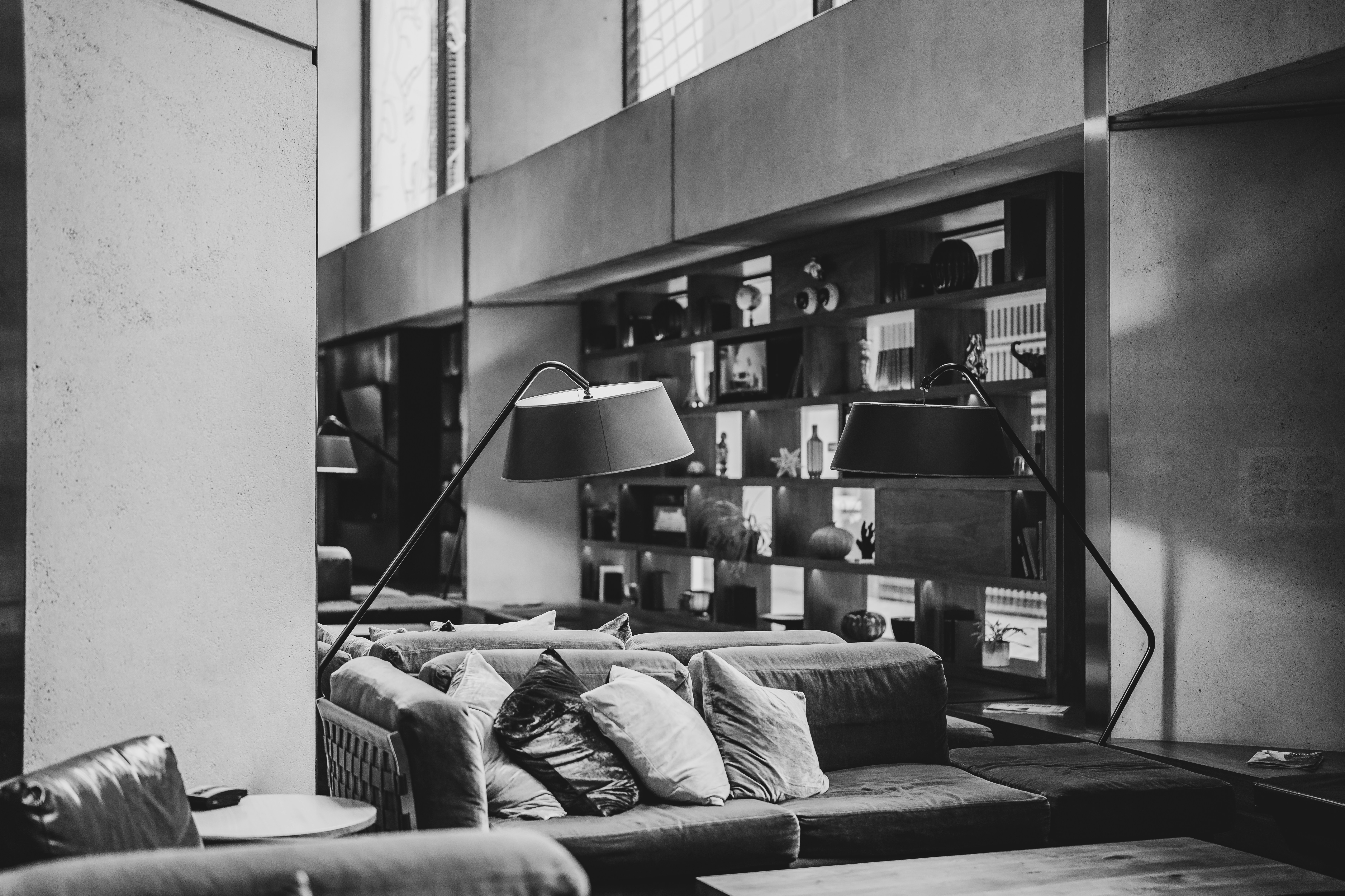 Modern lounge area with couch and floor lamps.