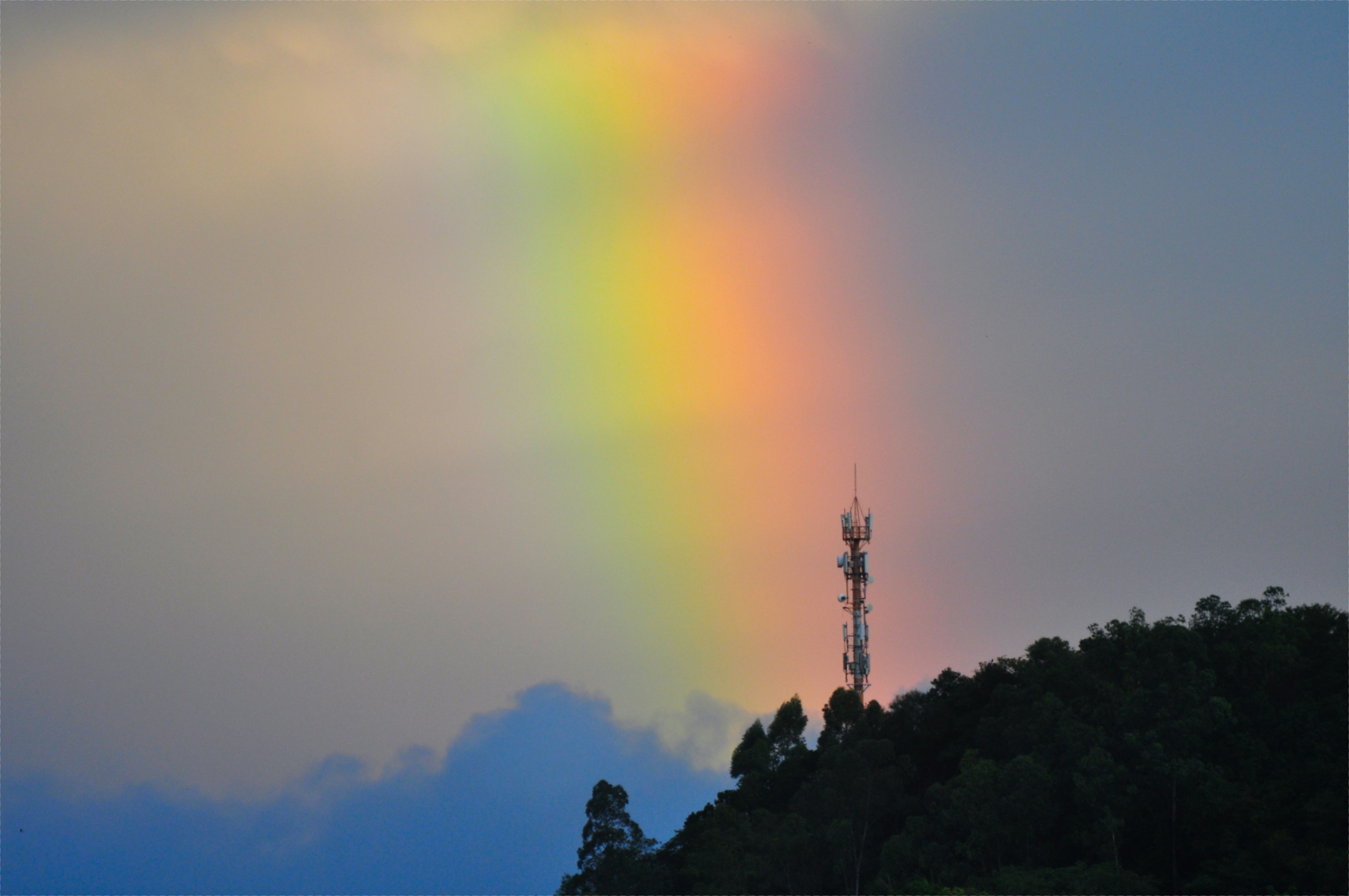 Rainbow over a hill with a cell tower. photo – Free Scenery Image on ...