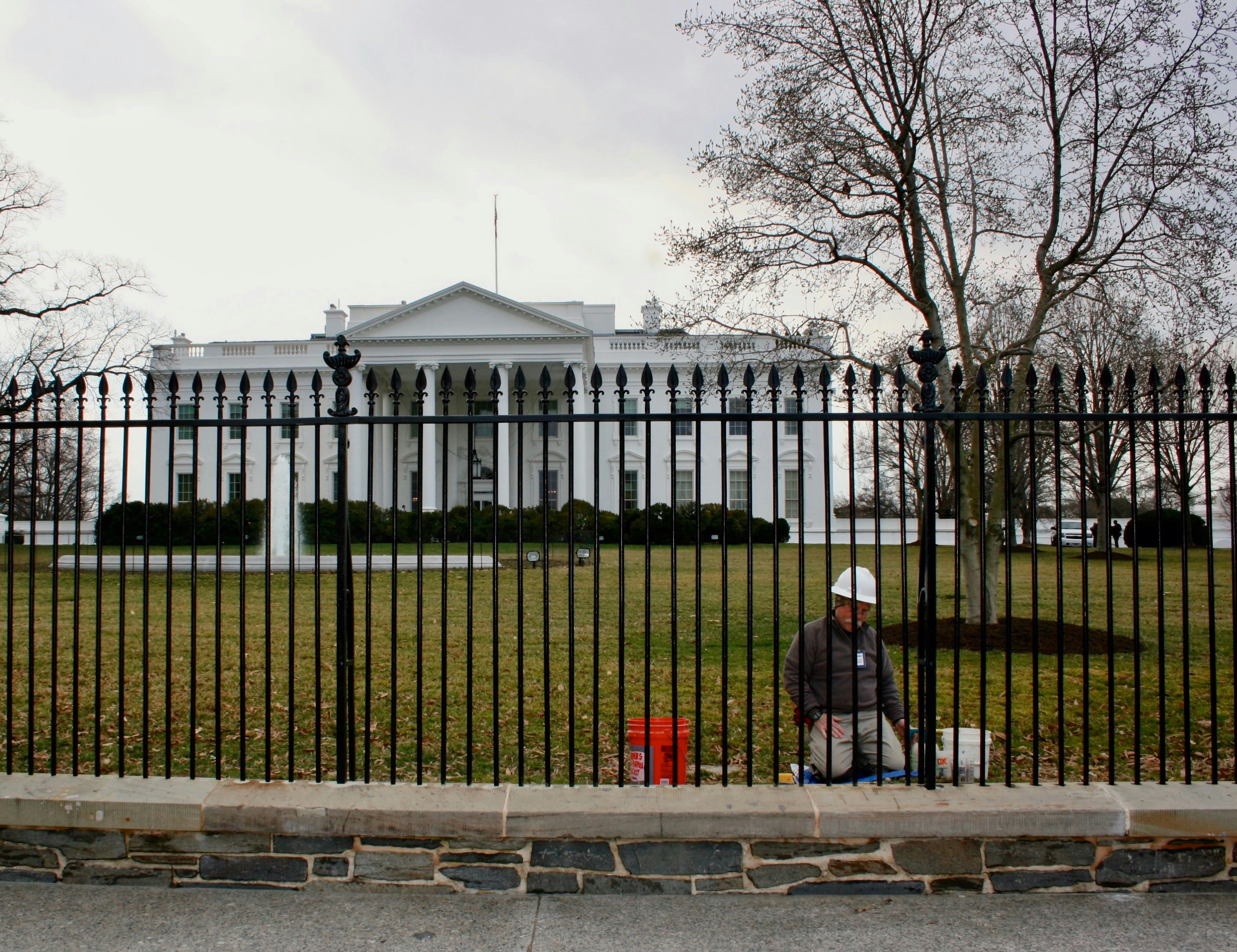 Handy mexican handyman at a White House | White house with a worker near the fence
