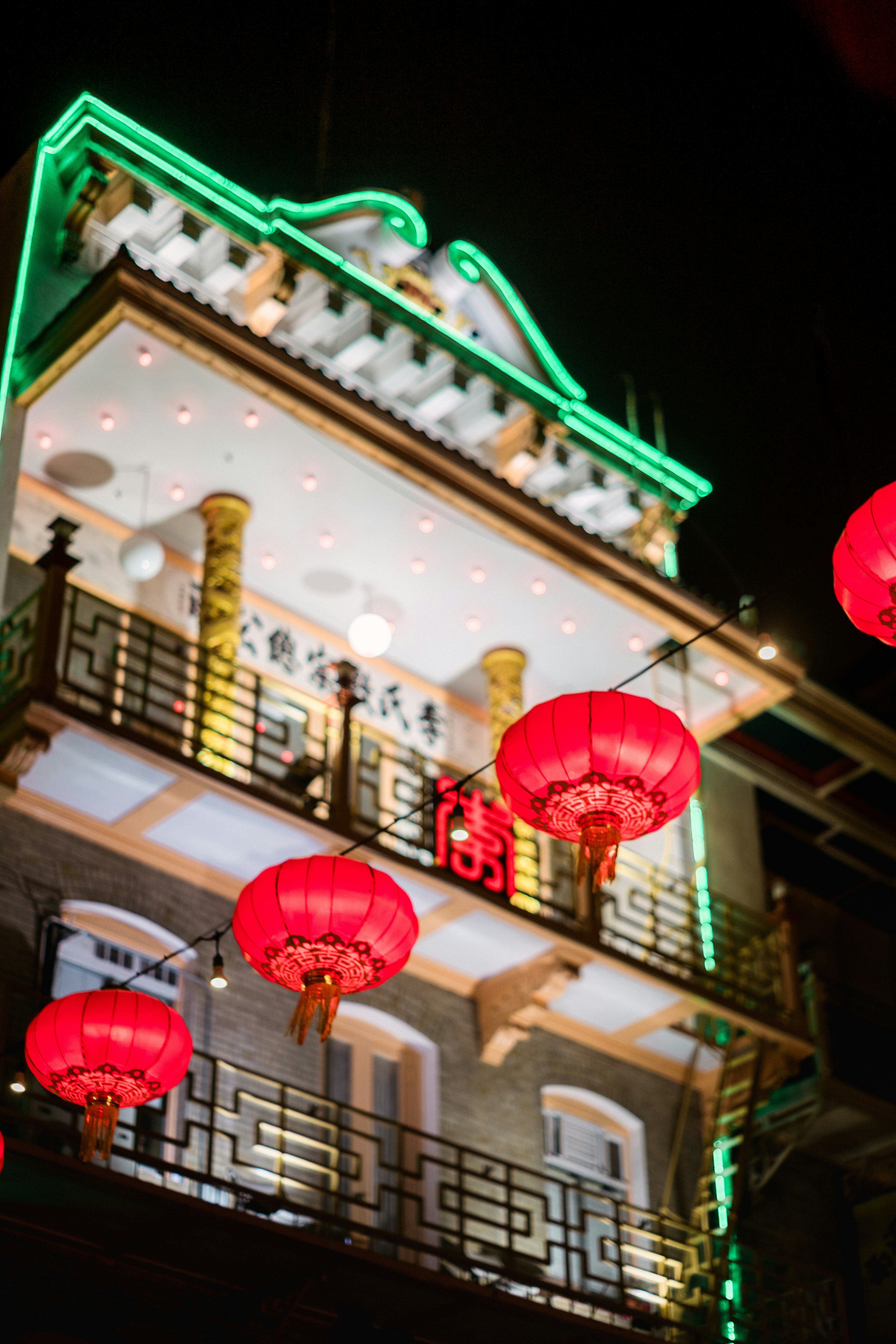 Red lanterns hang outside a building at night.