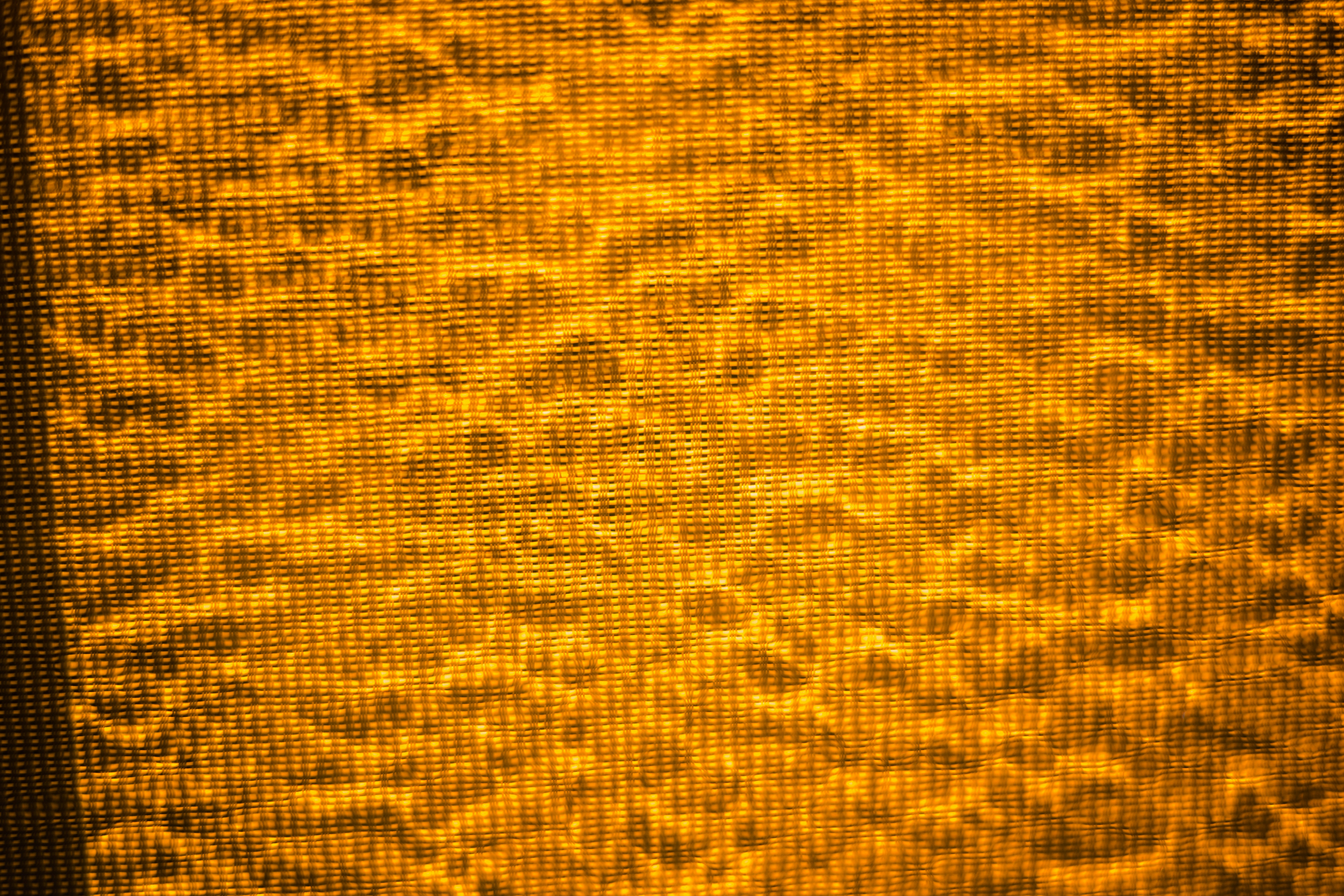 Abstract pattern of warm golden light on textured surface
