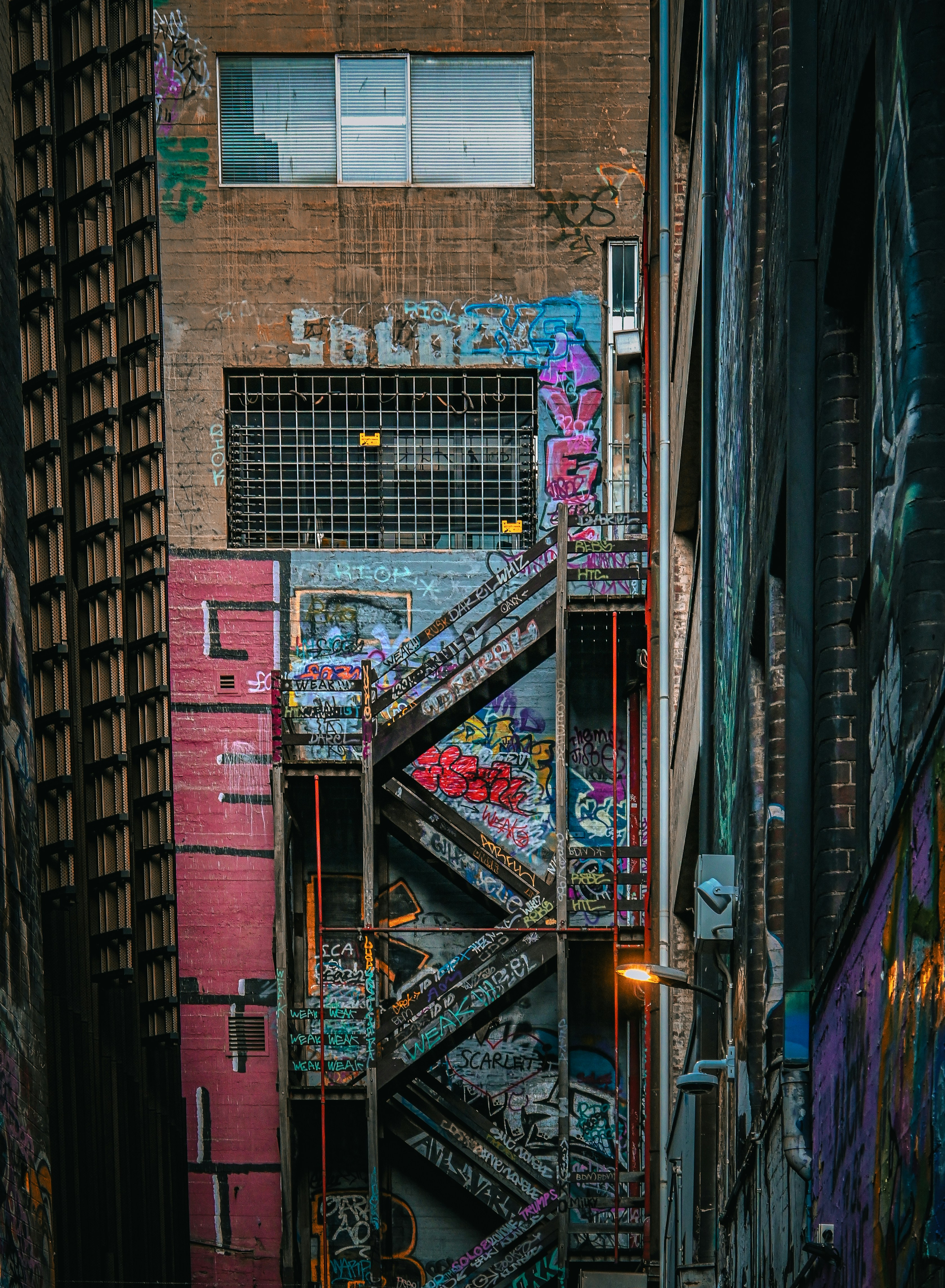 Graffiti-covered fire escape on a brick building