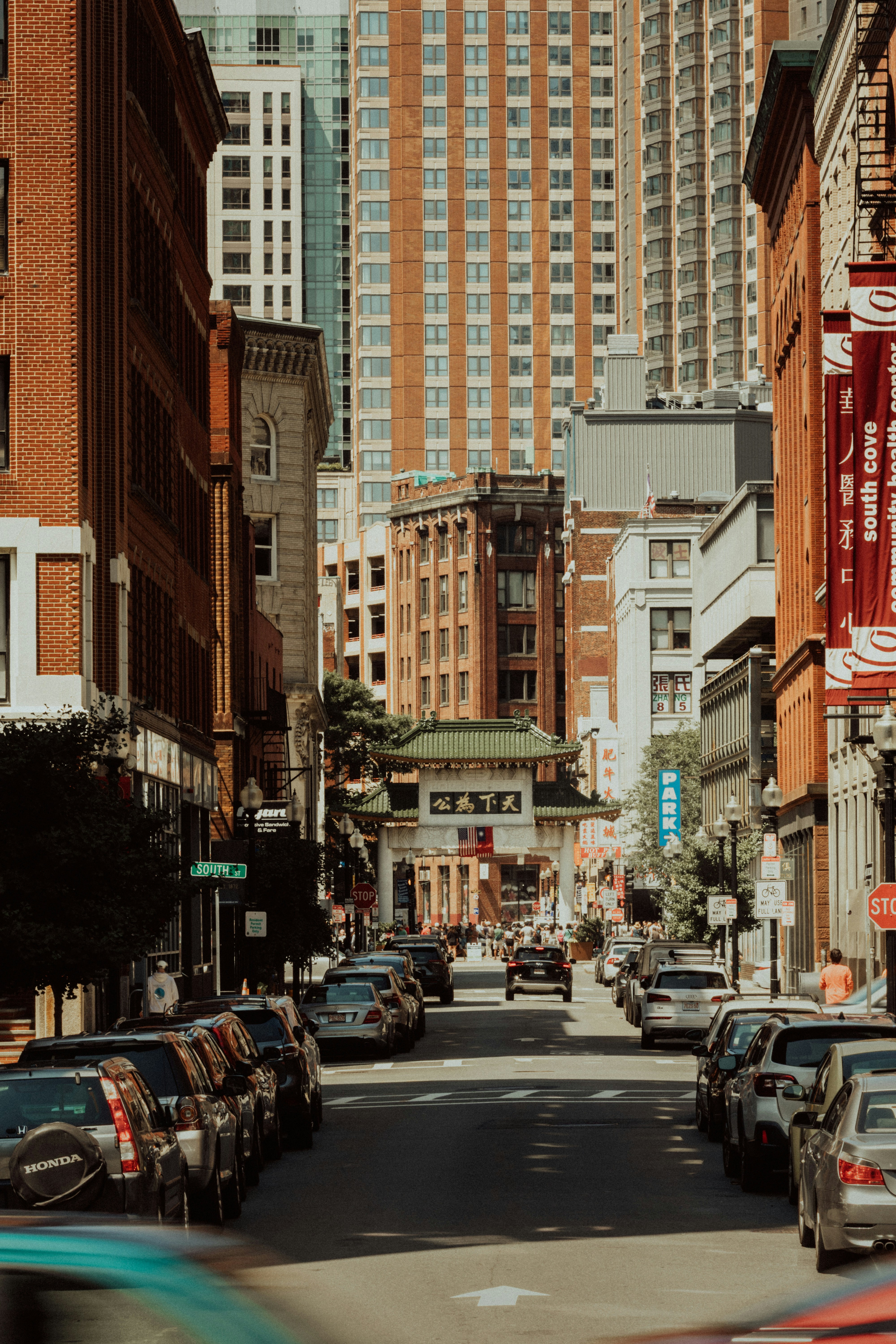 Cars parked along a city street with buildings.