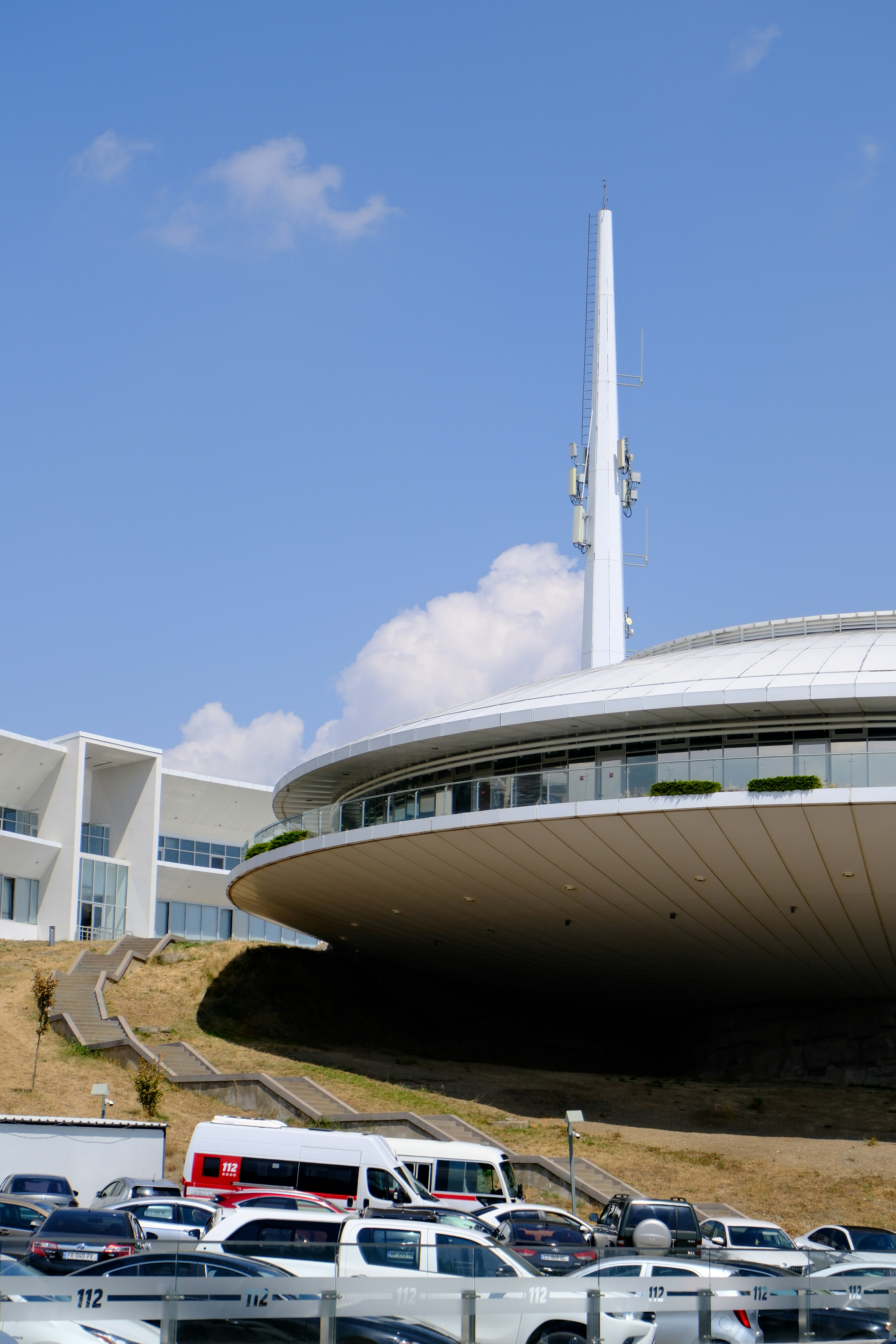 Modern building with antenna and parking lot