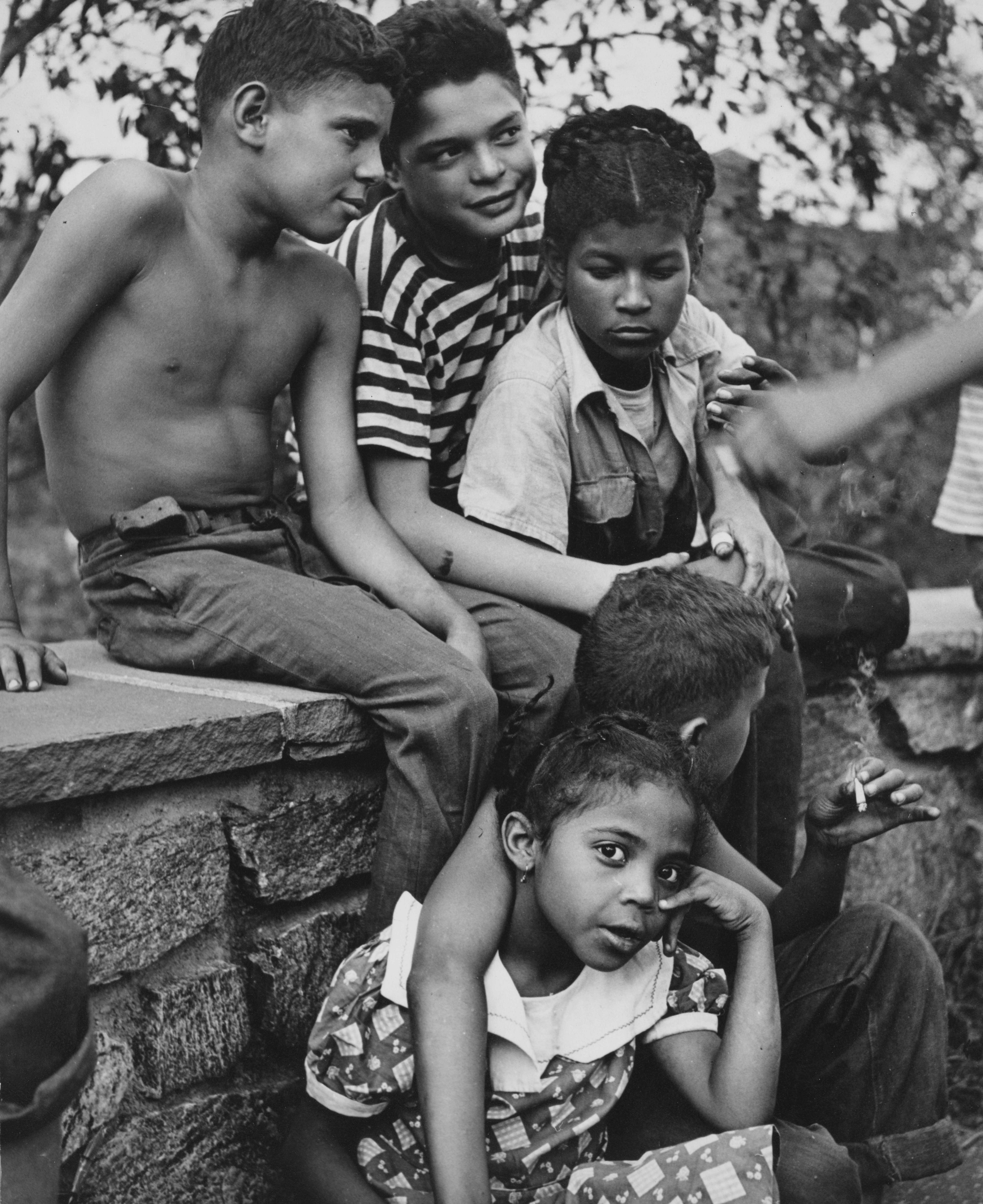 Schomburg Center for Research in Black Culture, Photographs and Prints Division, The New York Public Library. "Group of young kids seated outside embracing" The New York Public Library Digital Collections. 1947 - 1951. https://digitalcollections.nypl.org/items/447dbfe0-f5c5-013c-5d27-0242ac110006