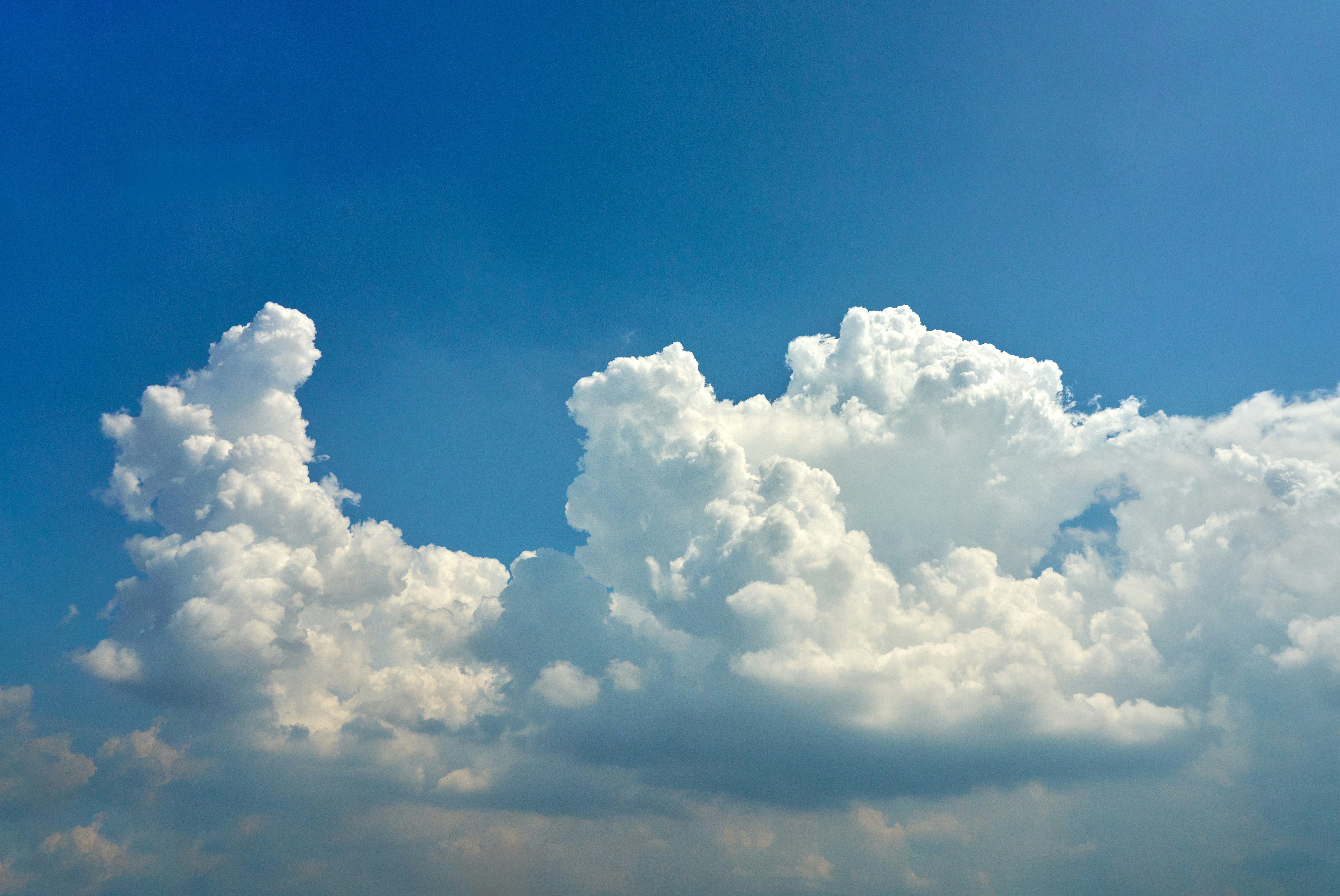 Fluffy white clouds against a clear blue sky