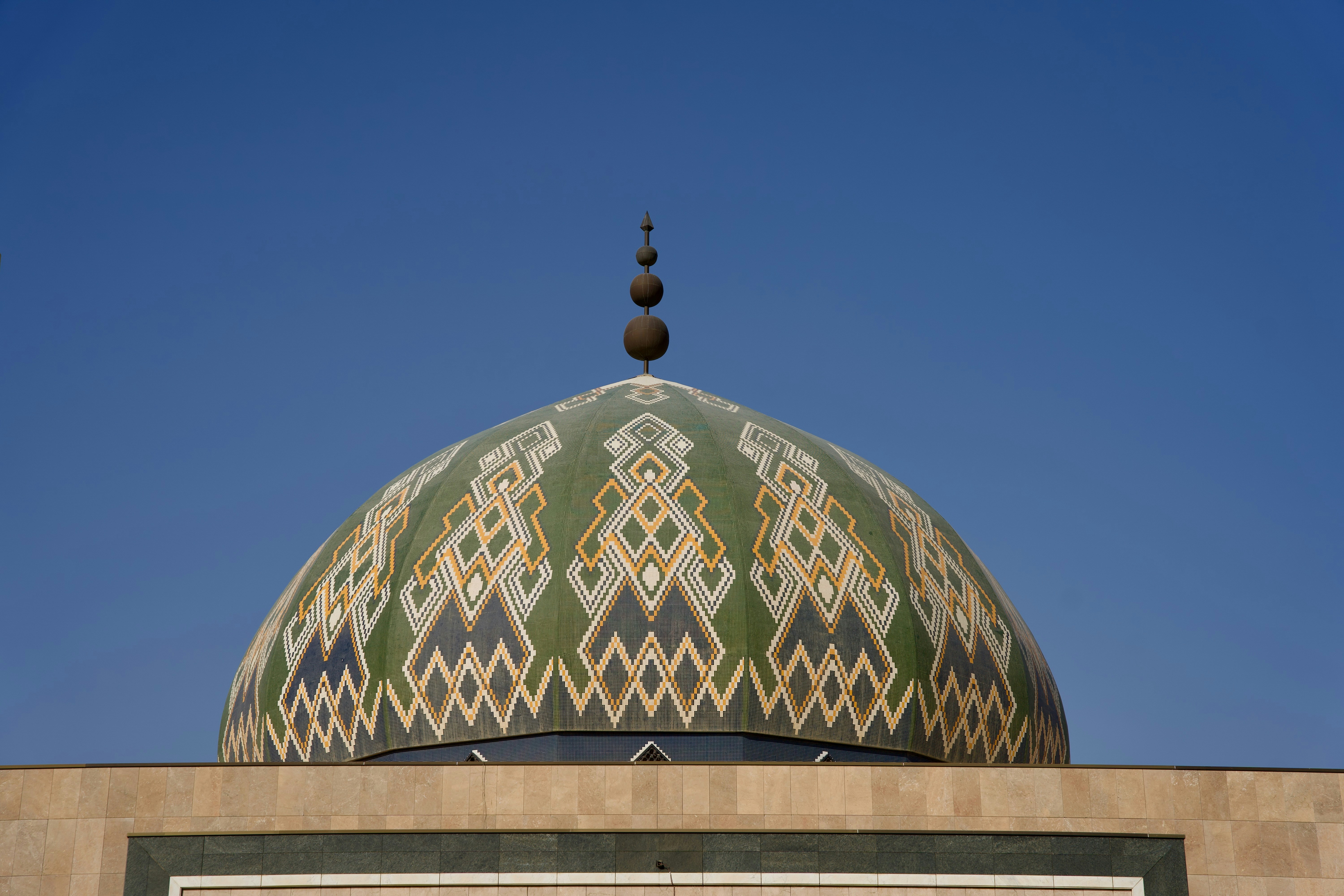 Ornate green dome of a building against blue sky