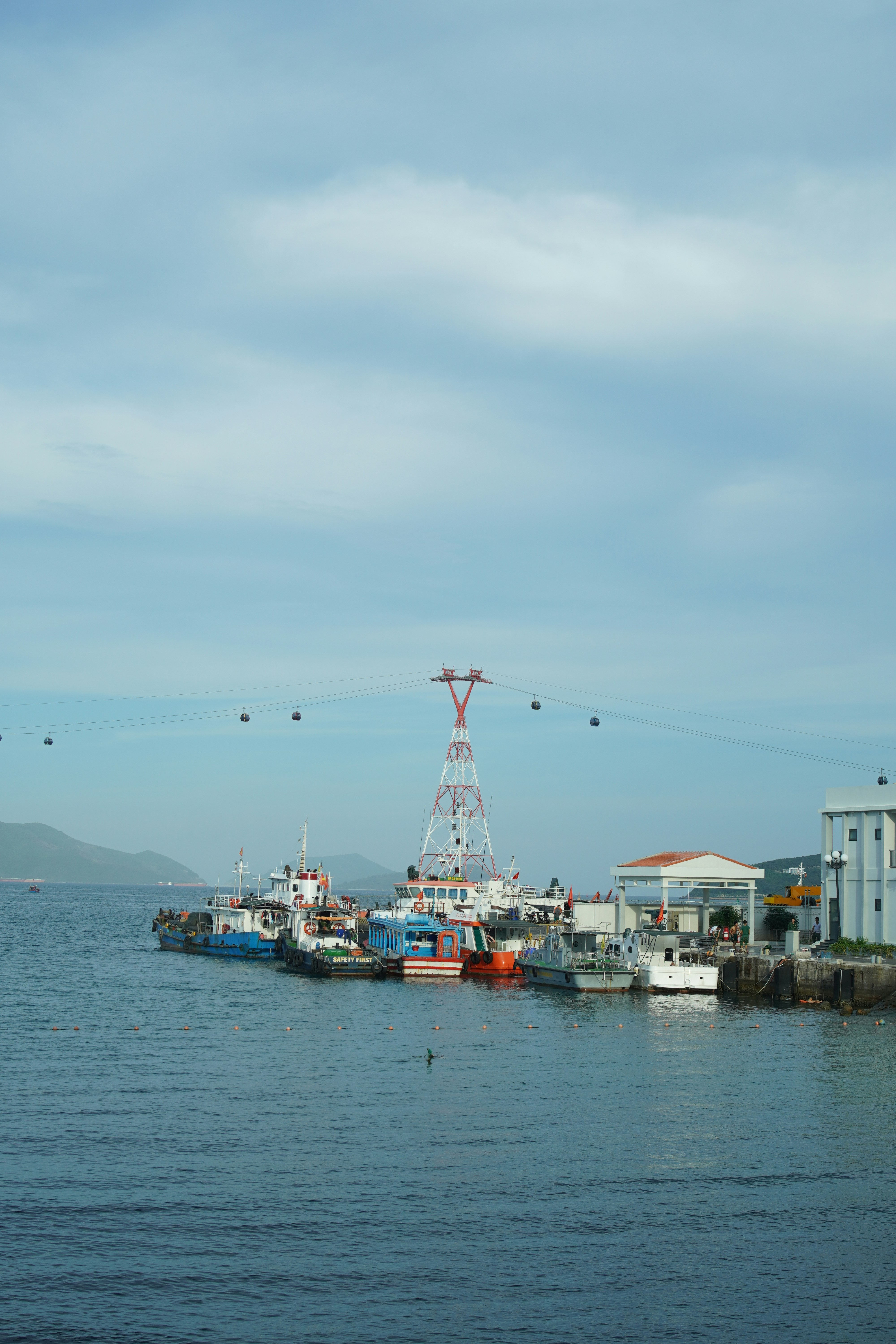 my city | Boats docked at a harbor with a cable car tower.