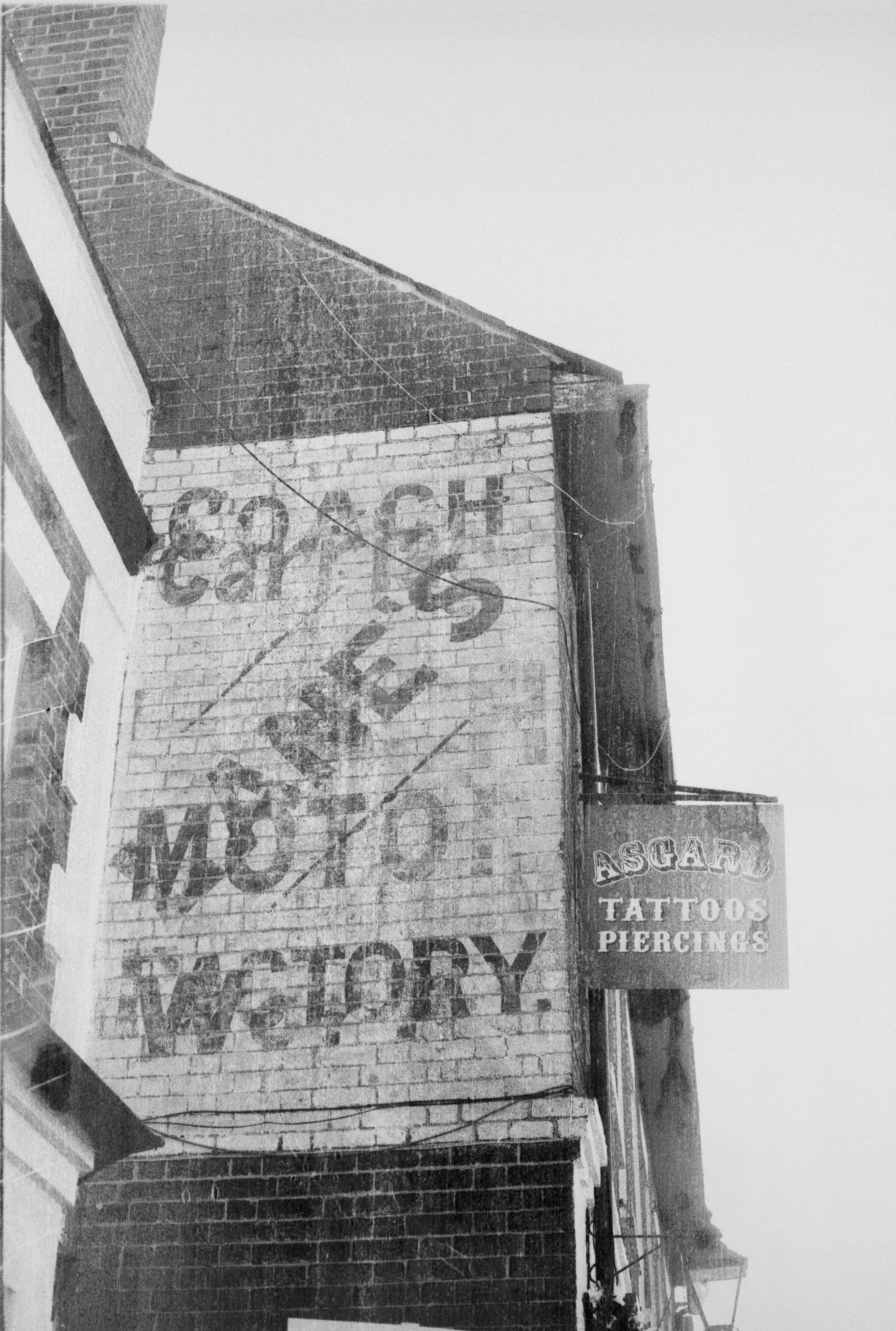 Old brick building with faded signs for coaches and motor victory.