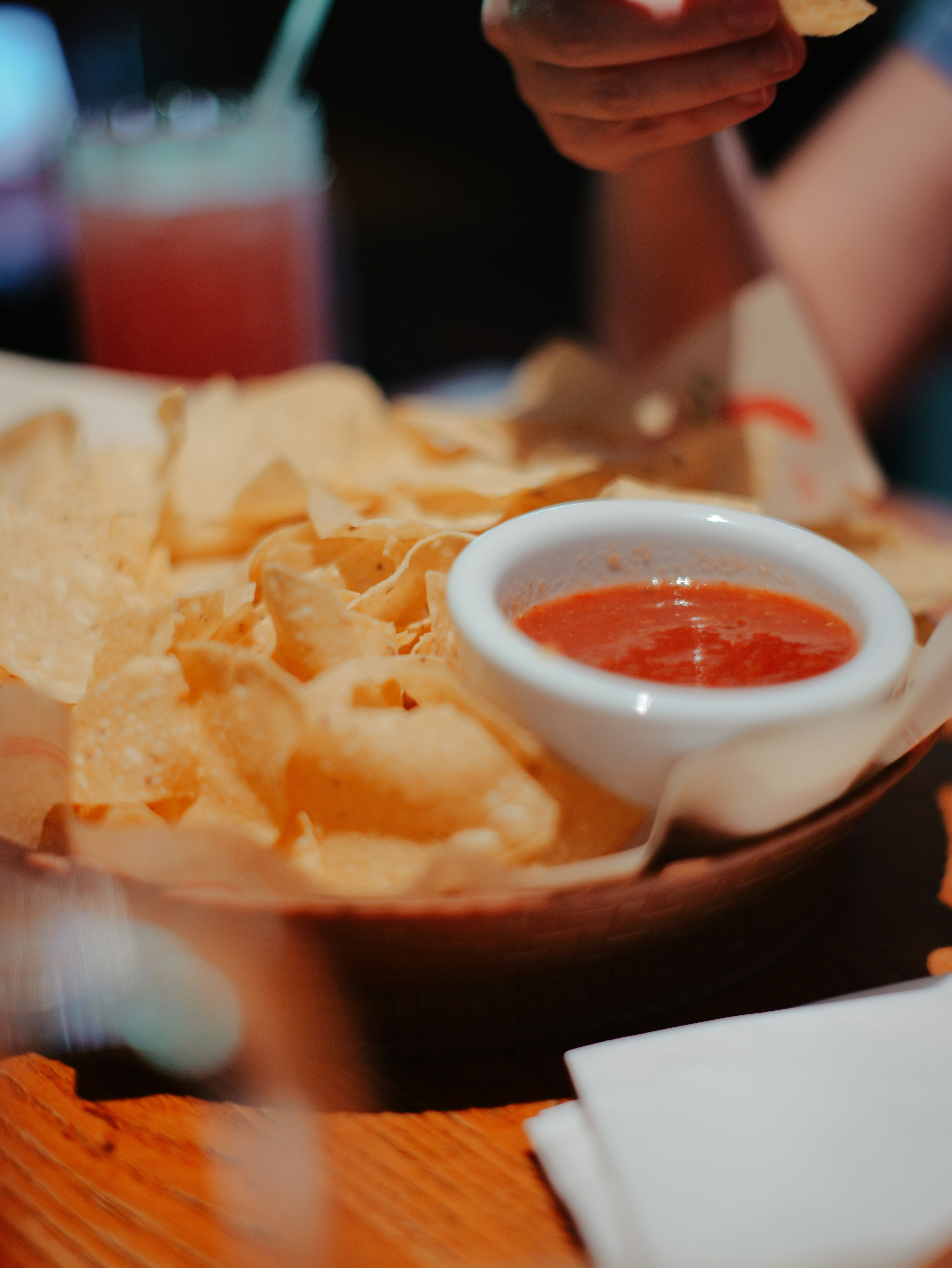 Basket of tortilla chips with salsa and drink