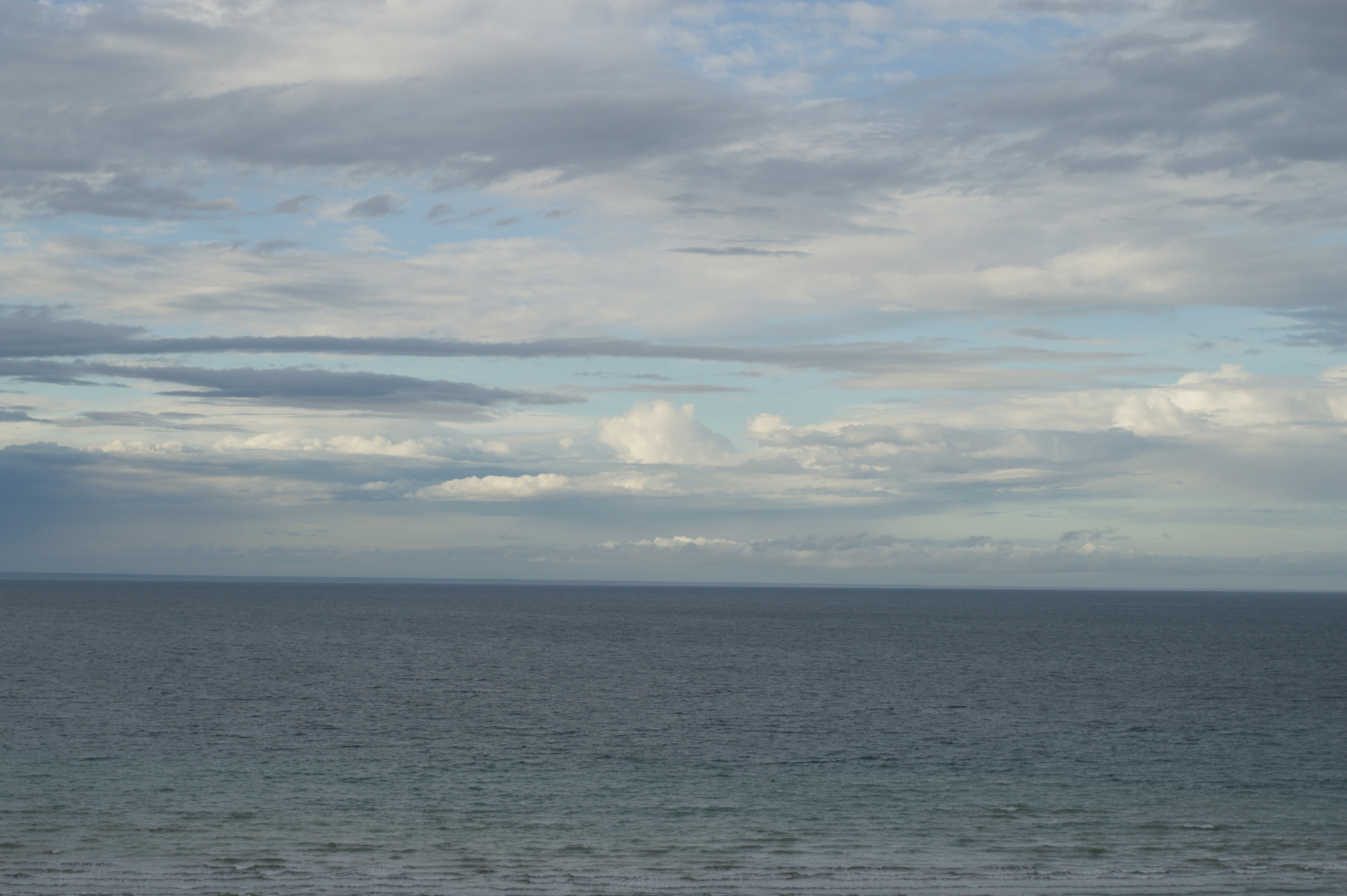 Calm ocean under a cloudy sky