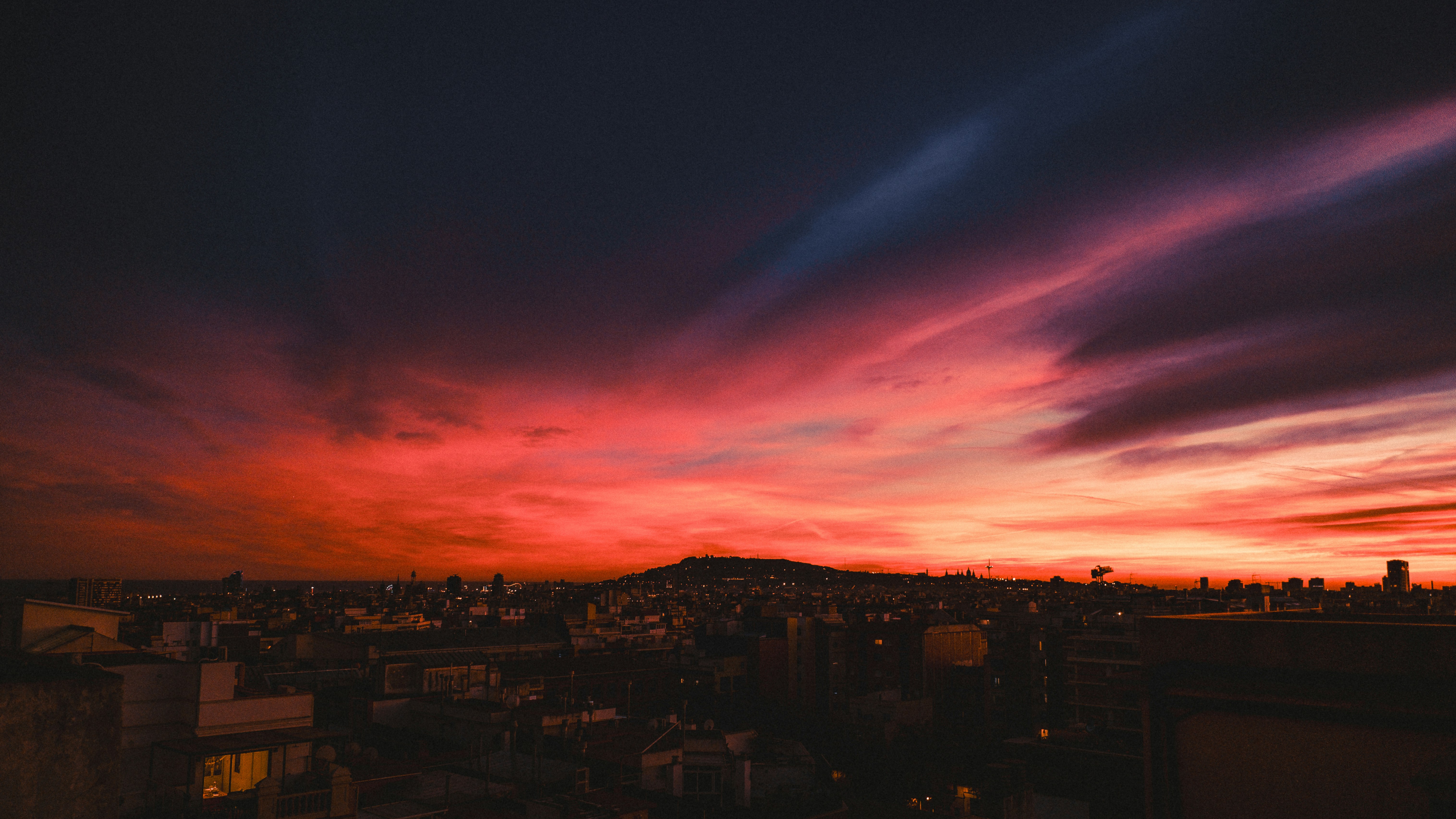 Vibrant sunset over a silhouetted cityscape