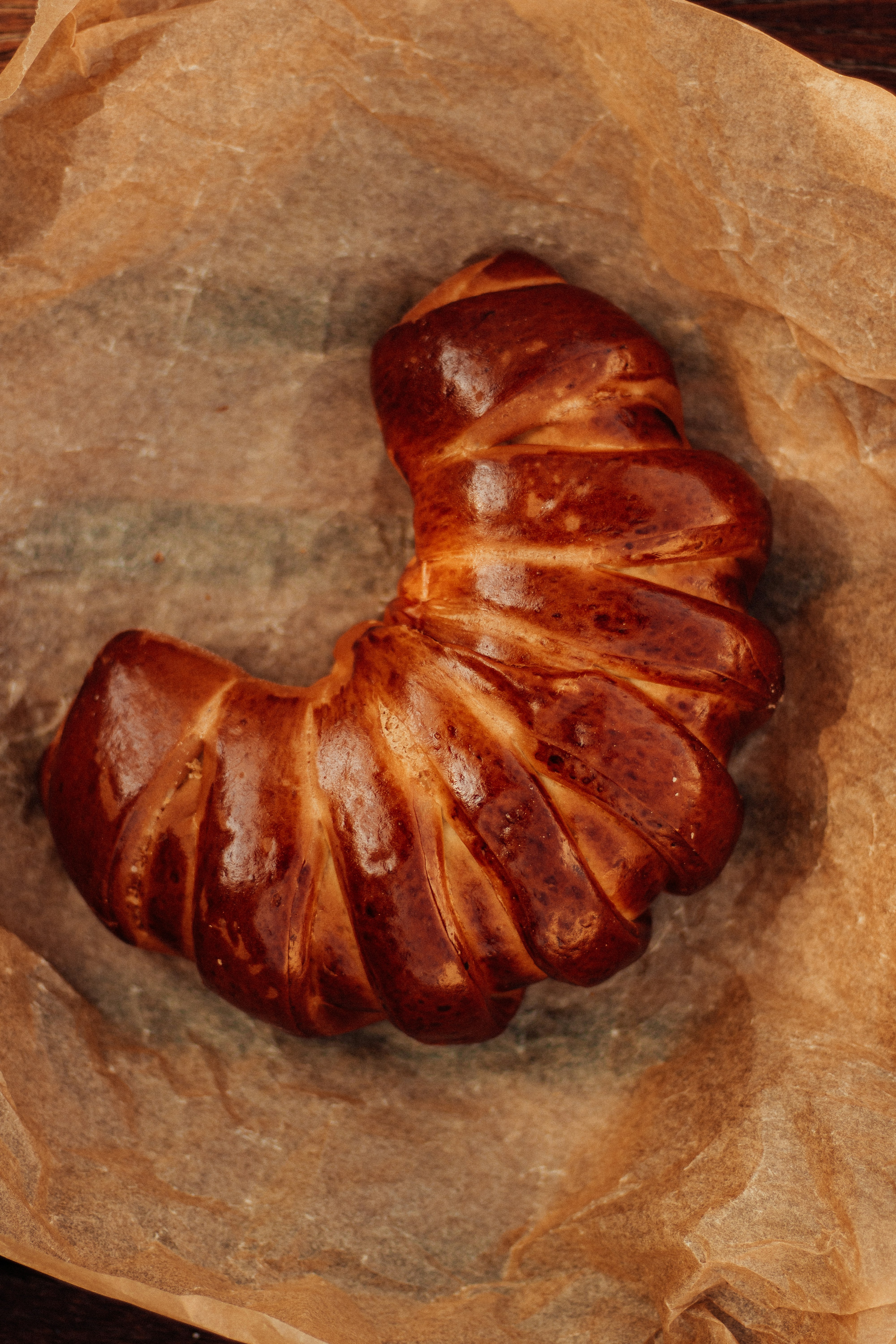 Freshly baked pastry with a spiral design resting on parchment paper.