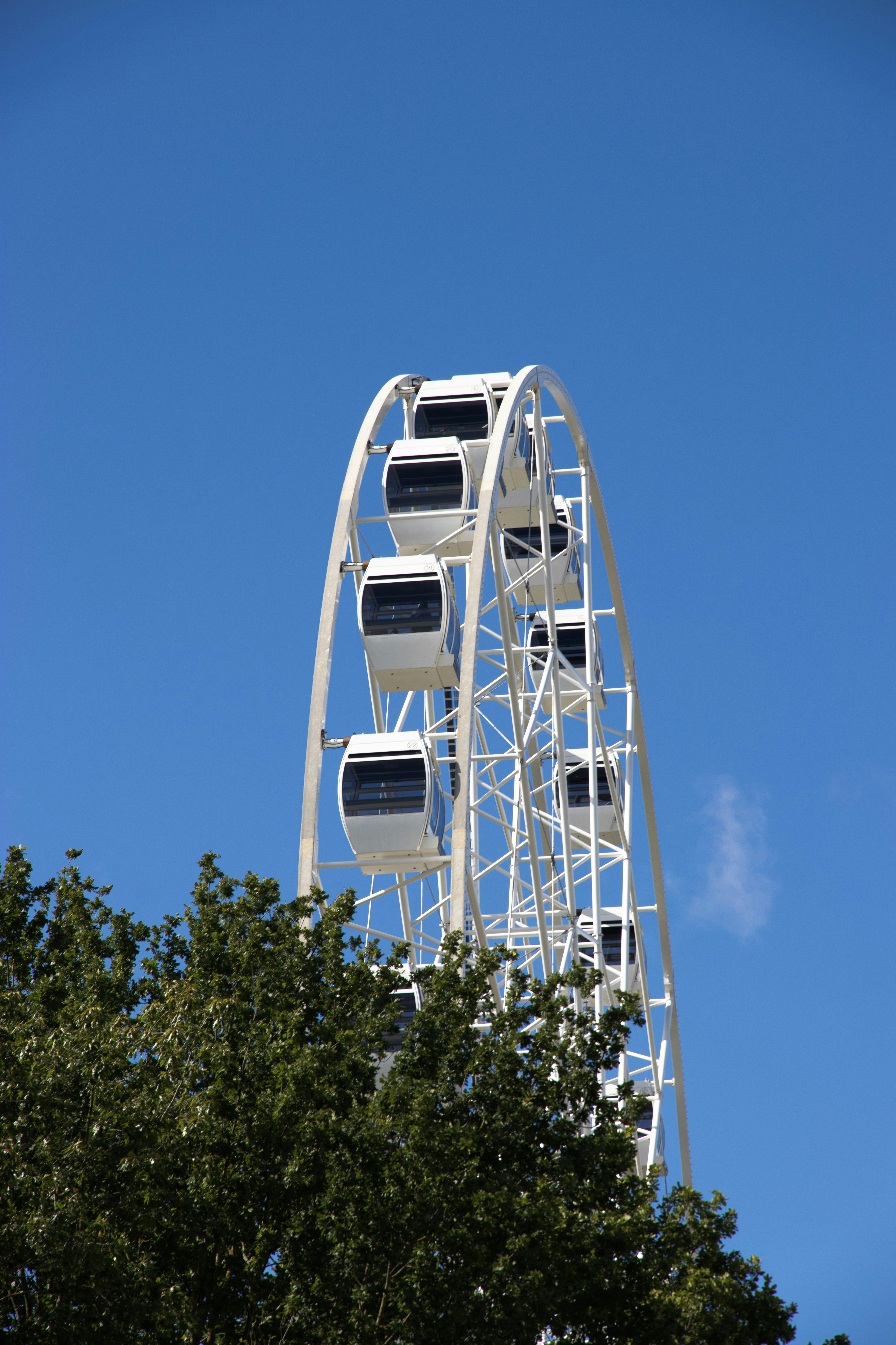 White ferris wheel against a clear blue sky