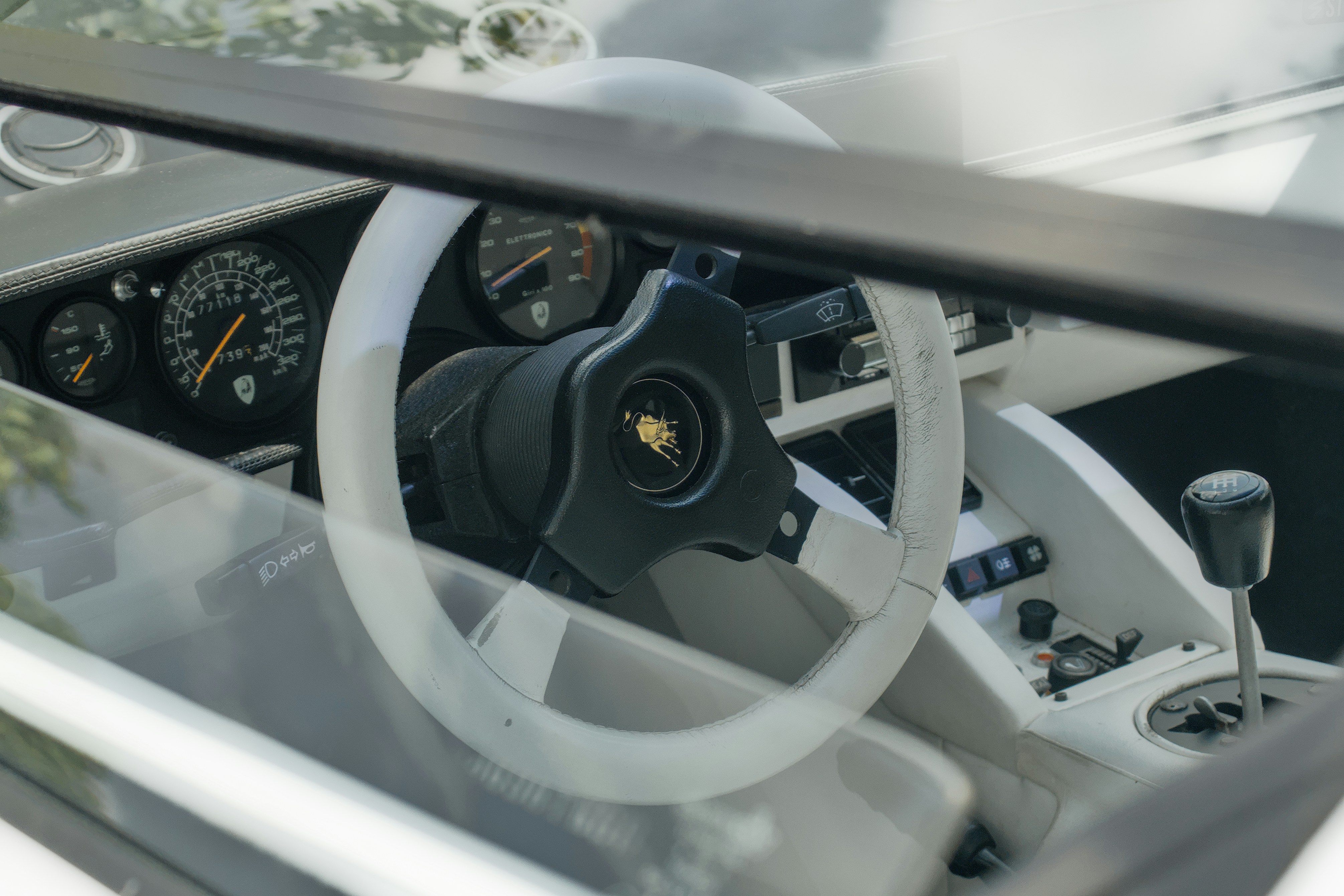Interior view of a classic car showcasing a detailed steering wheel and dashboard controls. The design reflects a blend of vintage aesthetics and modern functionality.