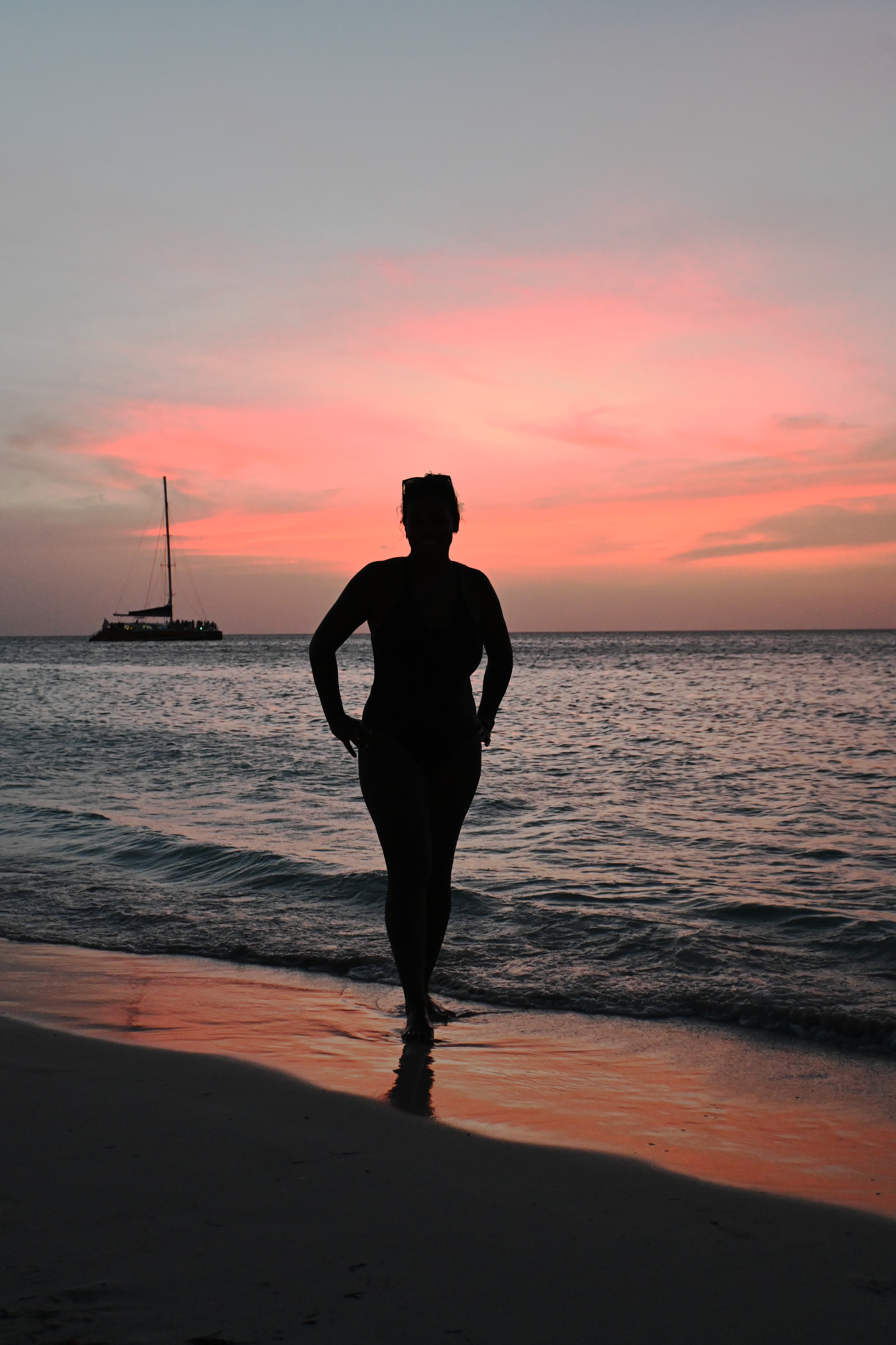 Silhouette of a woman on a beach at sunset.