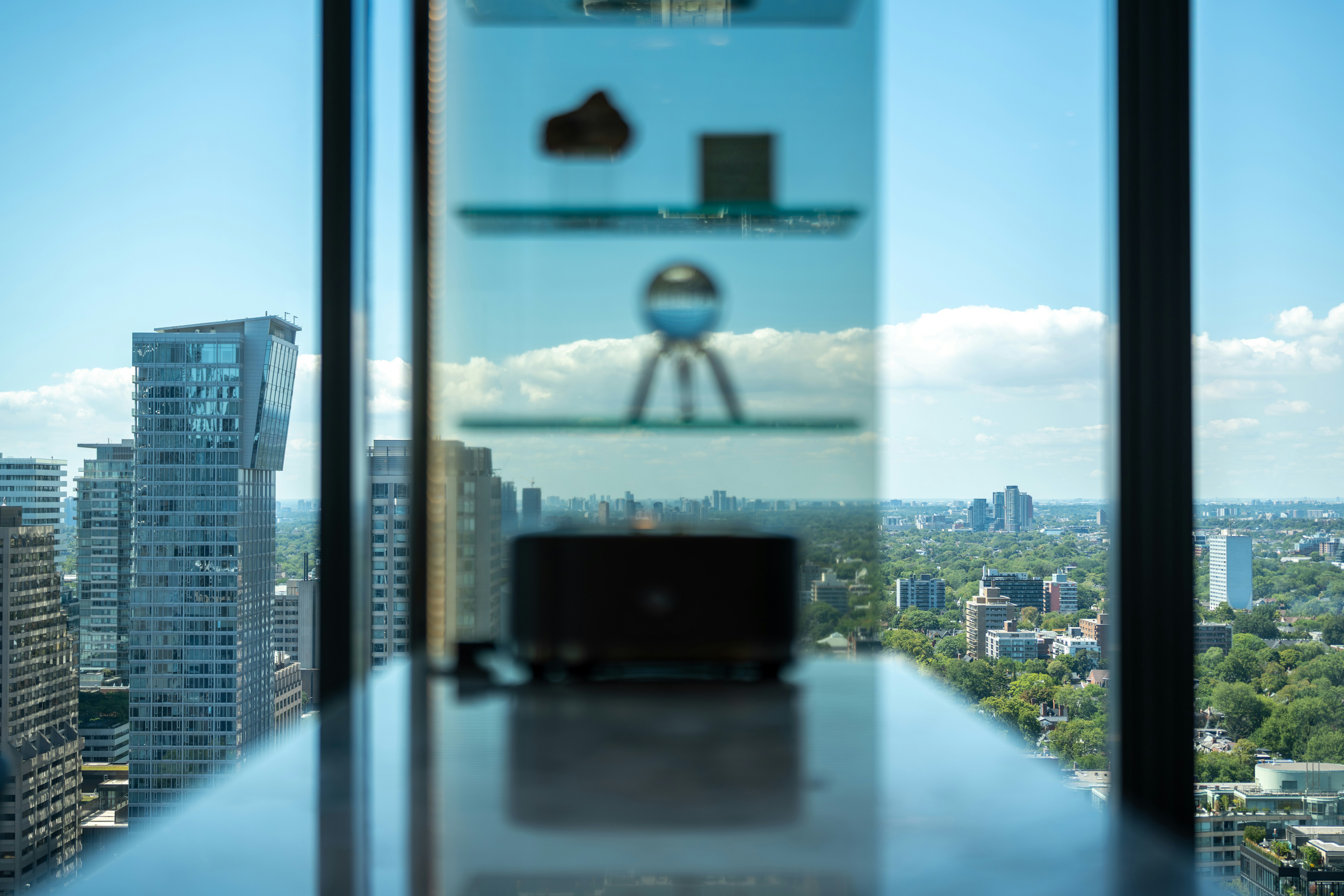 View of city skyline through a window with shelves.